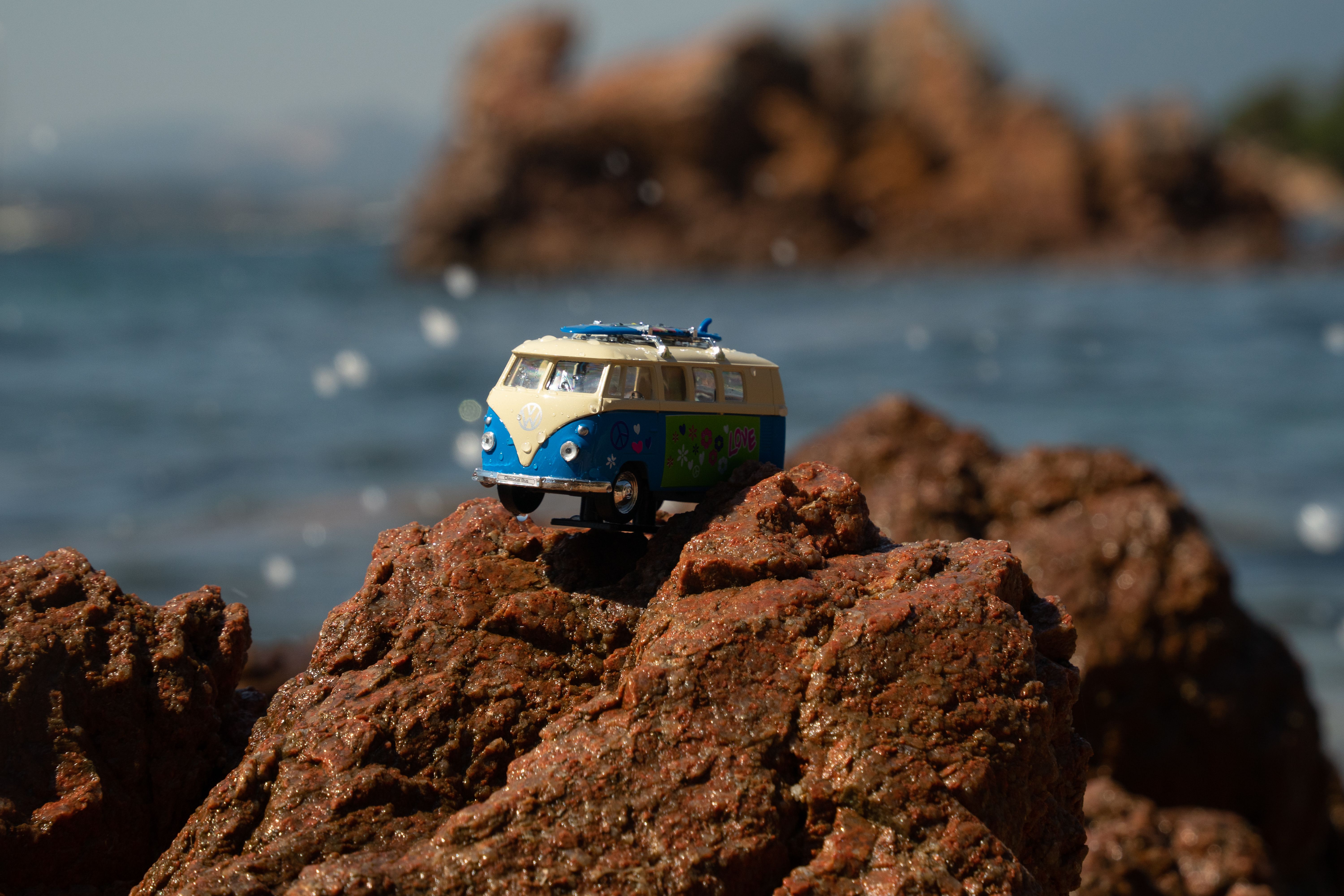 A toy bus on top of a rock in the ocean · Free Stock Photo