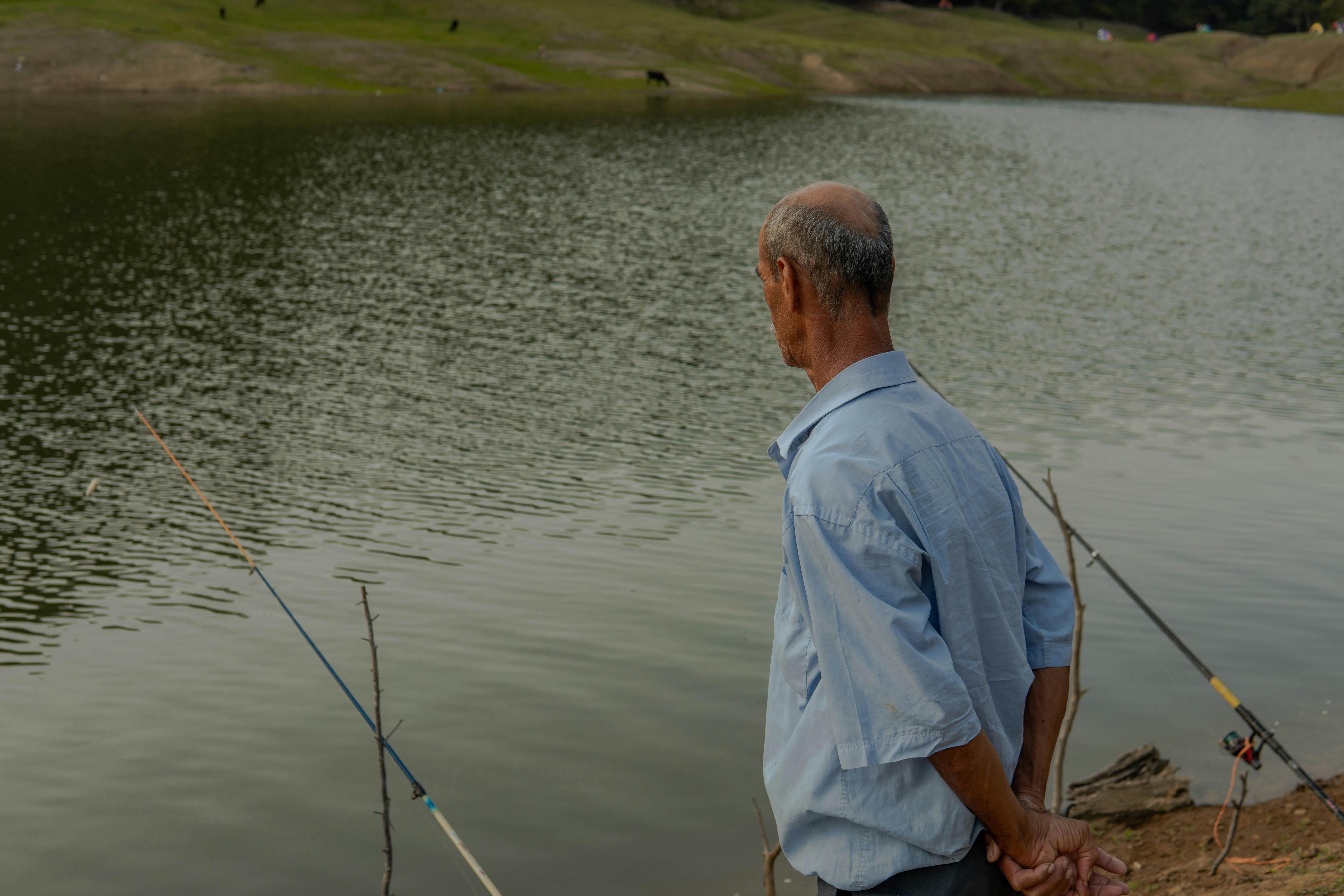 Angler Standing on Beach and Looking at Water · Free Stock Photo