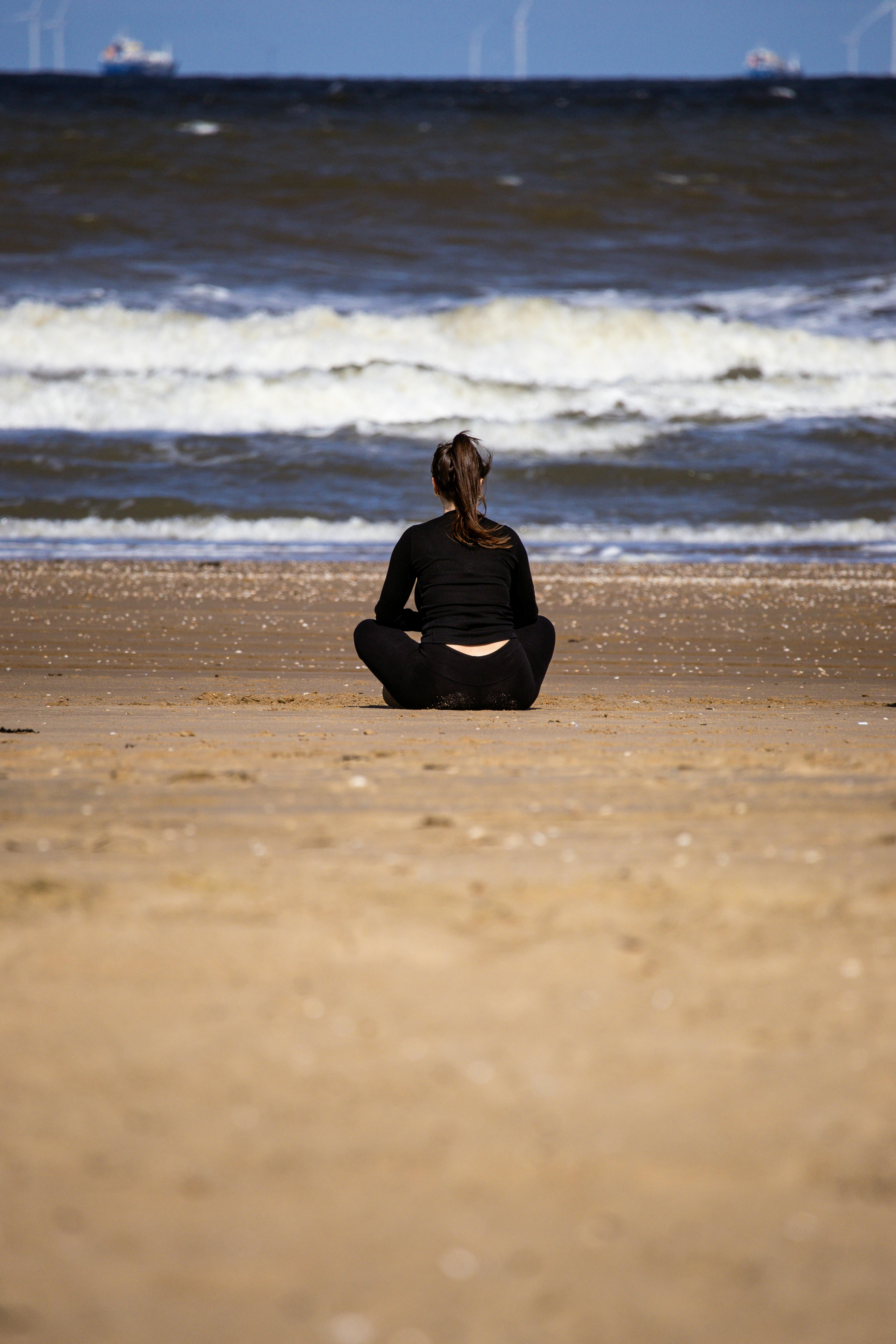 Back View of a Woman in a Bikini Sitting on the Beach · Free Stock Photo