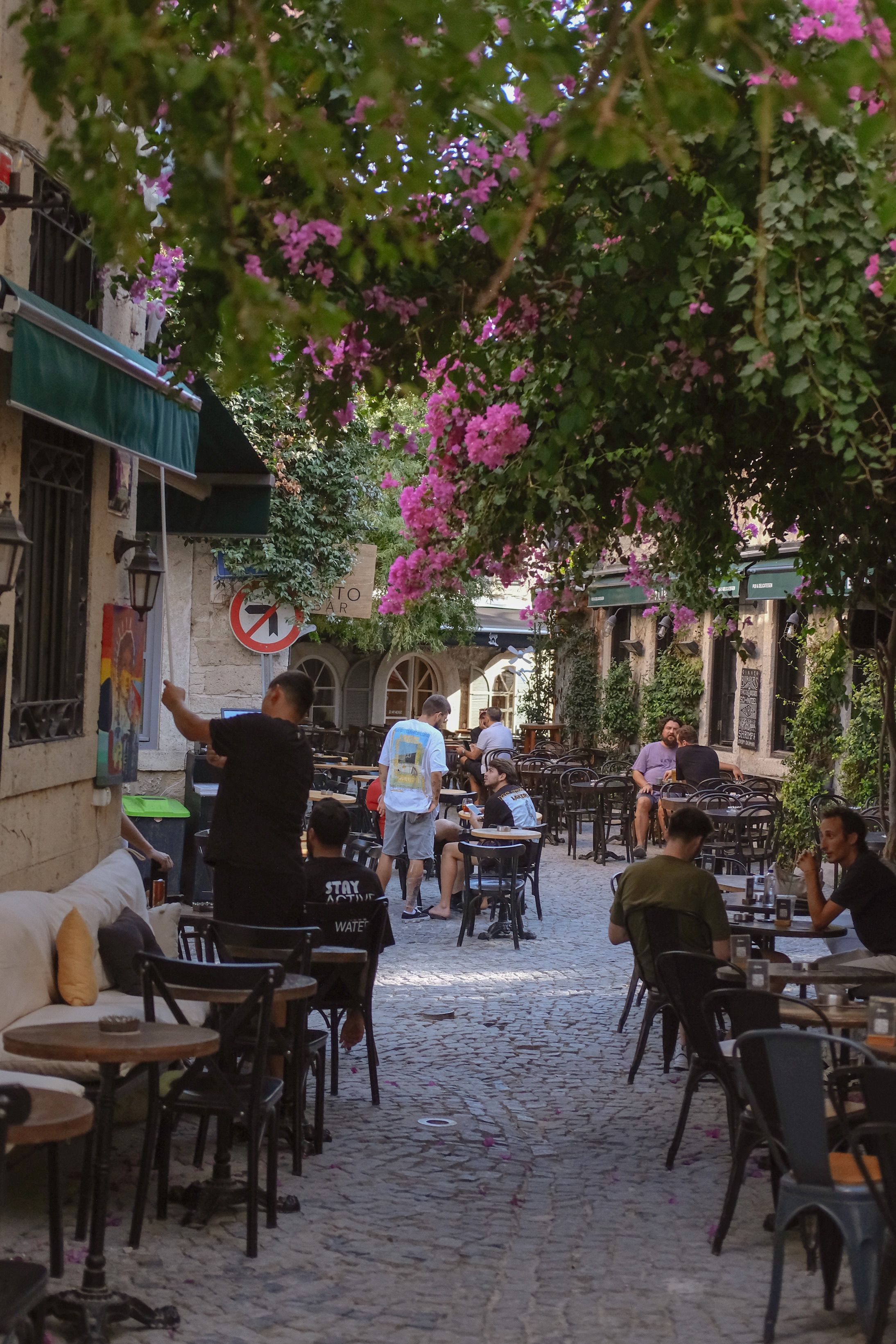 People at Cafe Terrace on Paved Narrow Street · Free Stock Photo