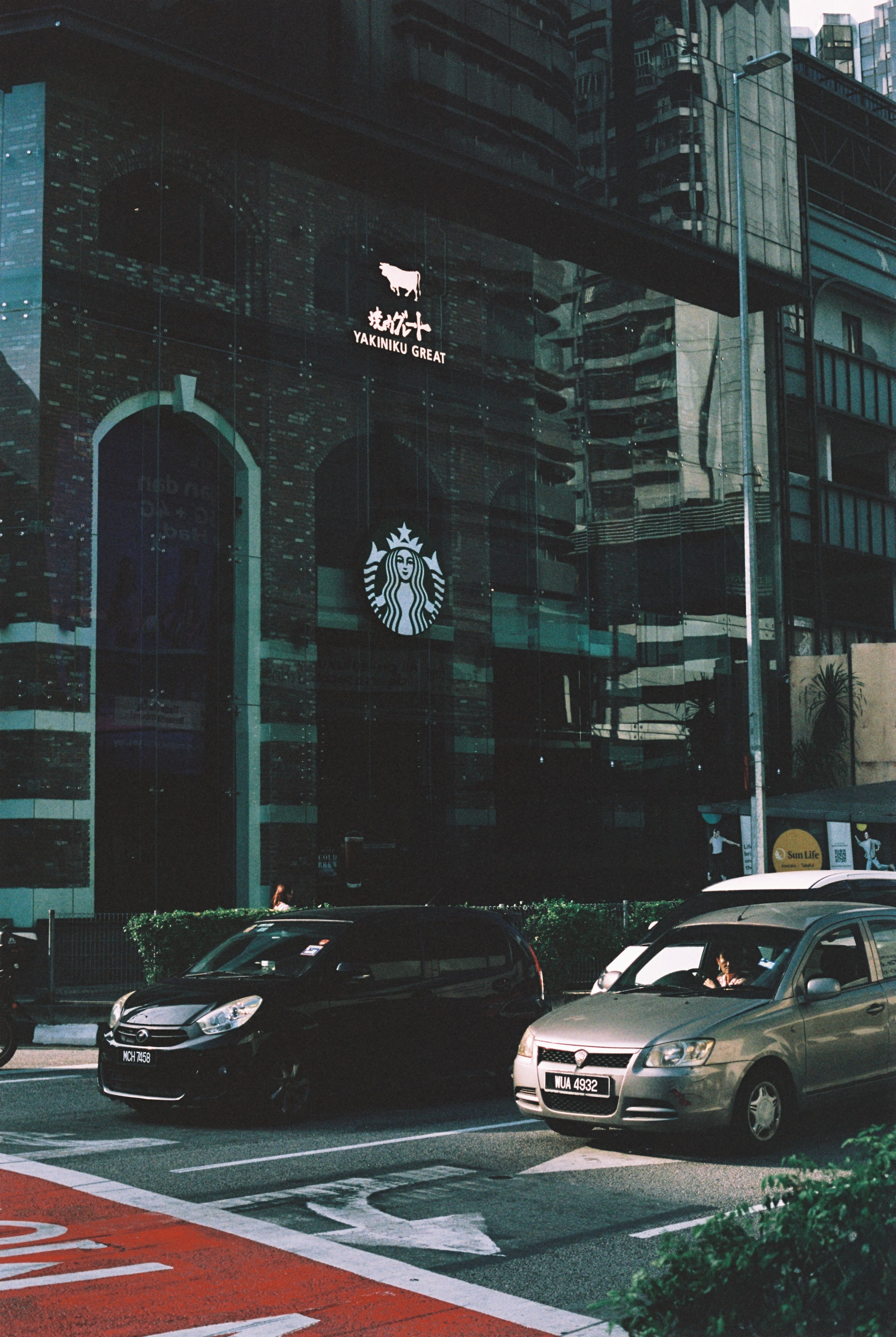Cars Waiting on a City Street near Starbucks Cafe · Free Stock Photo
