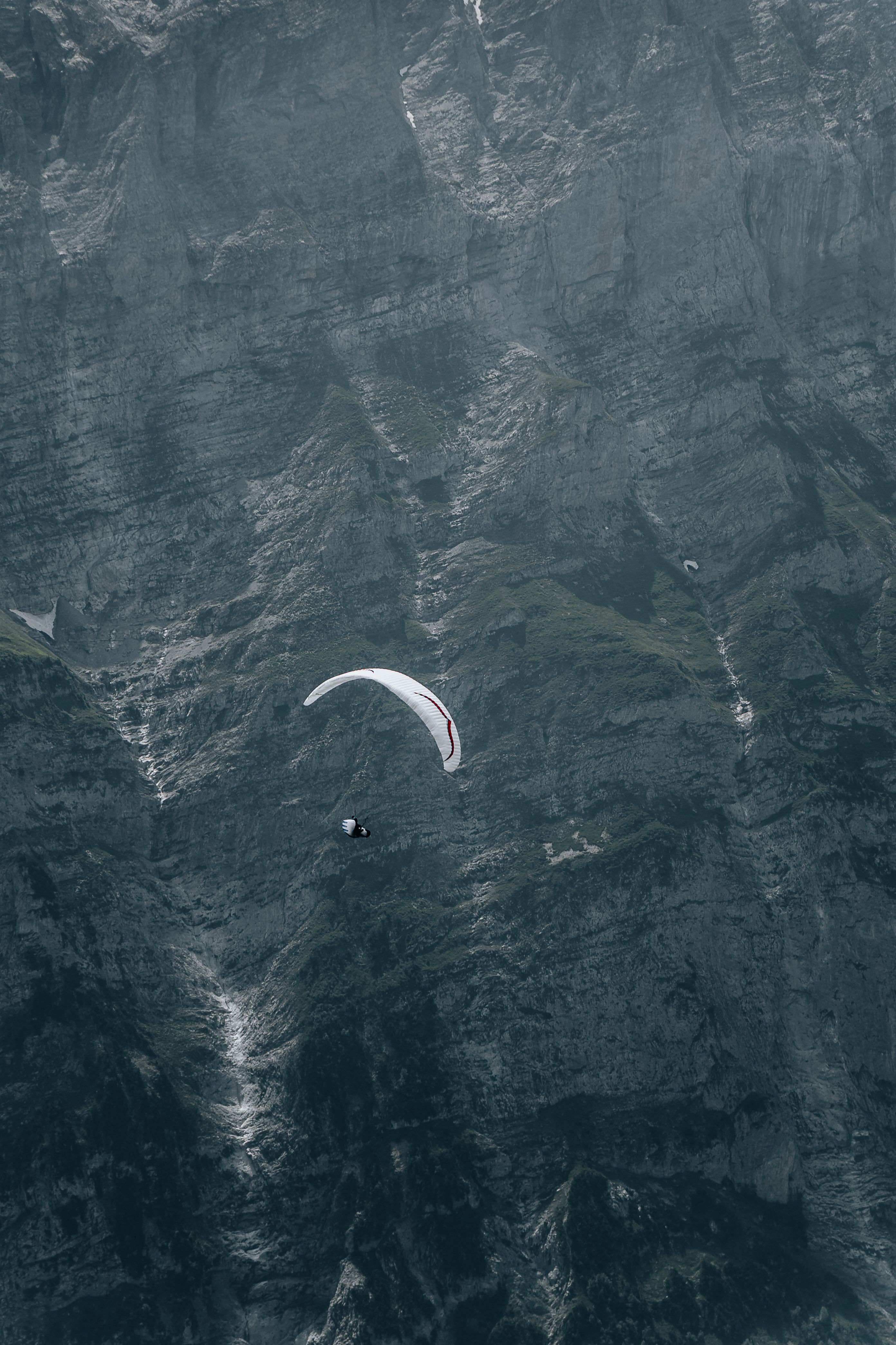 Person Flying on Glide in Steep Rocky Mountains · Free Stock Photo