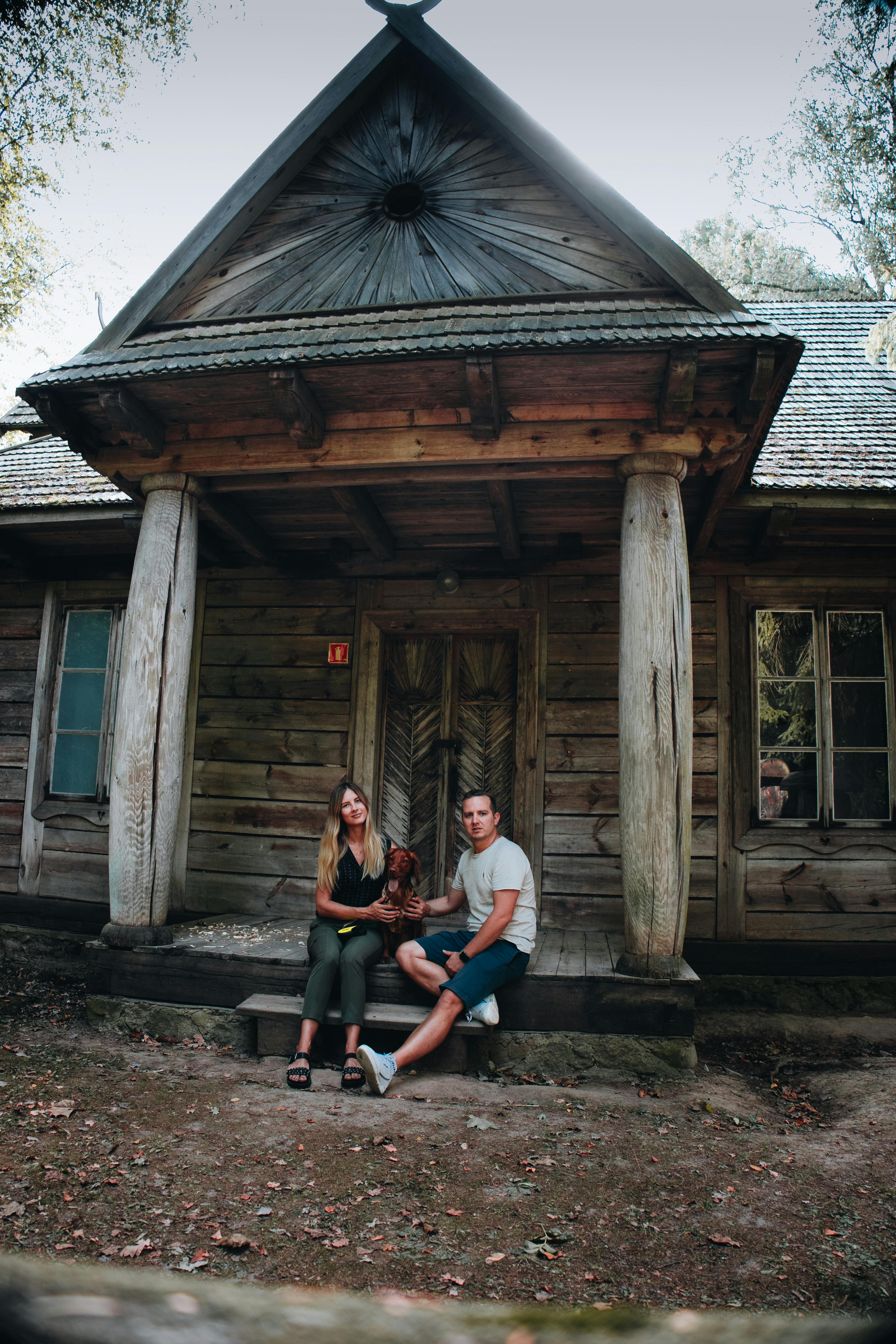 Couple Sitting in Front of a Wooden Hut · Free Stock Photo