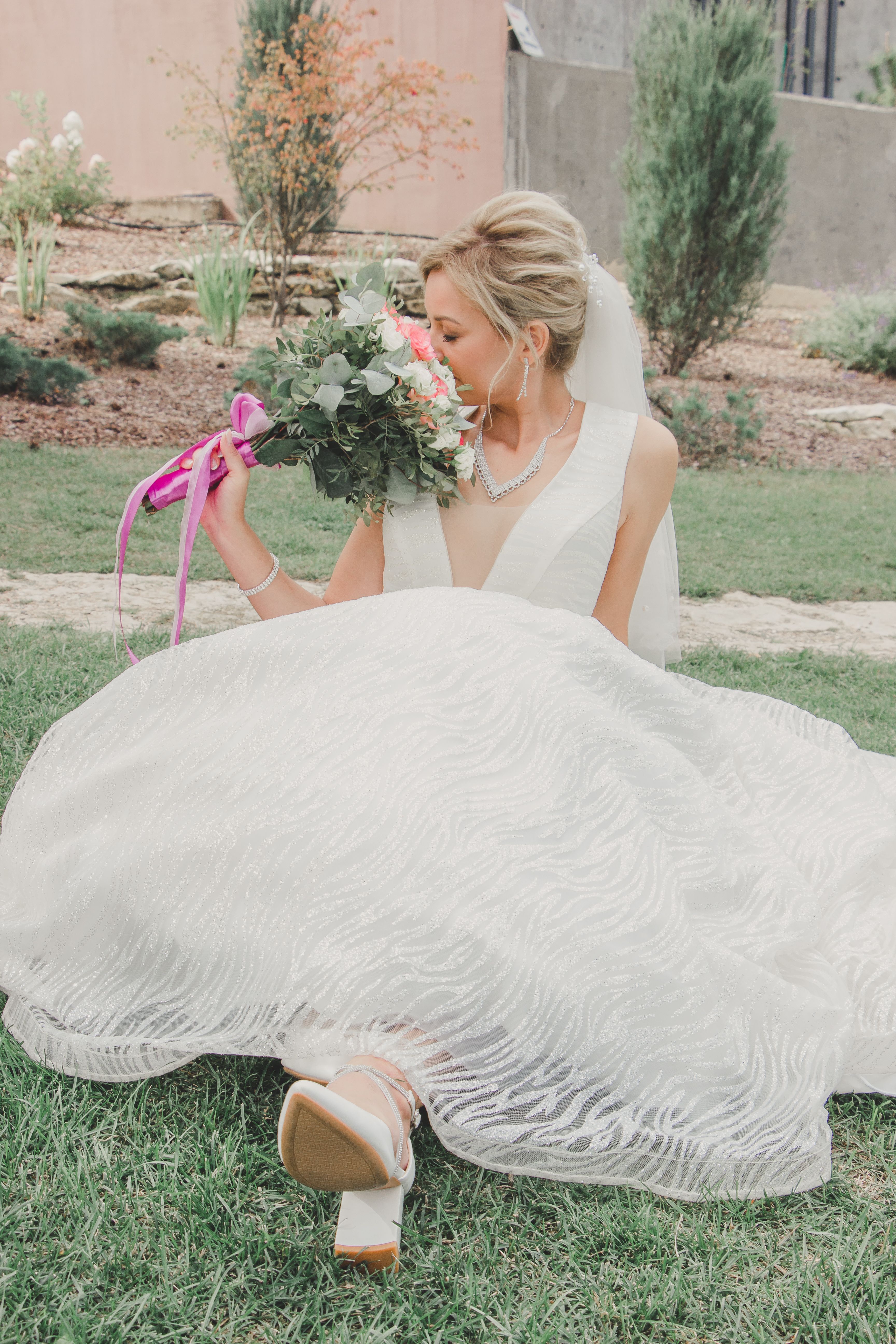 Bride Sitting and Posing in Dress with Wings · Free Stock Photo