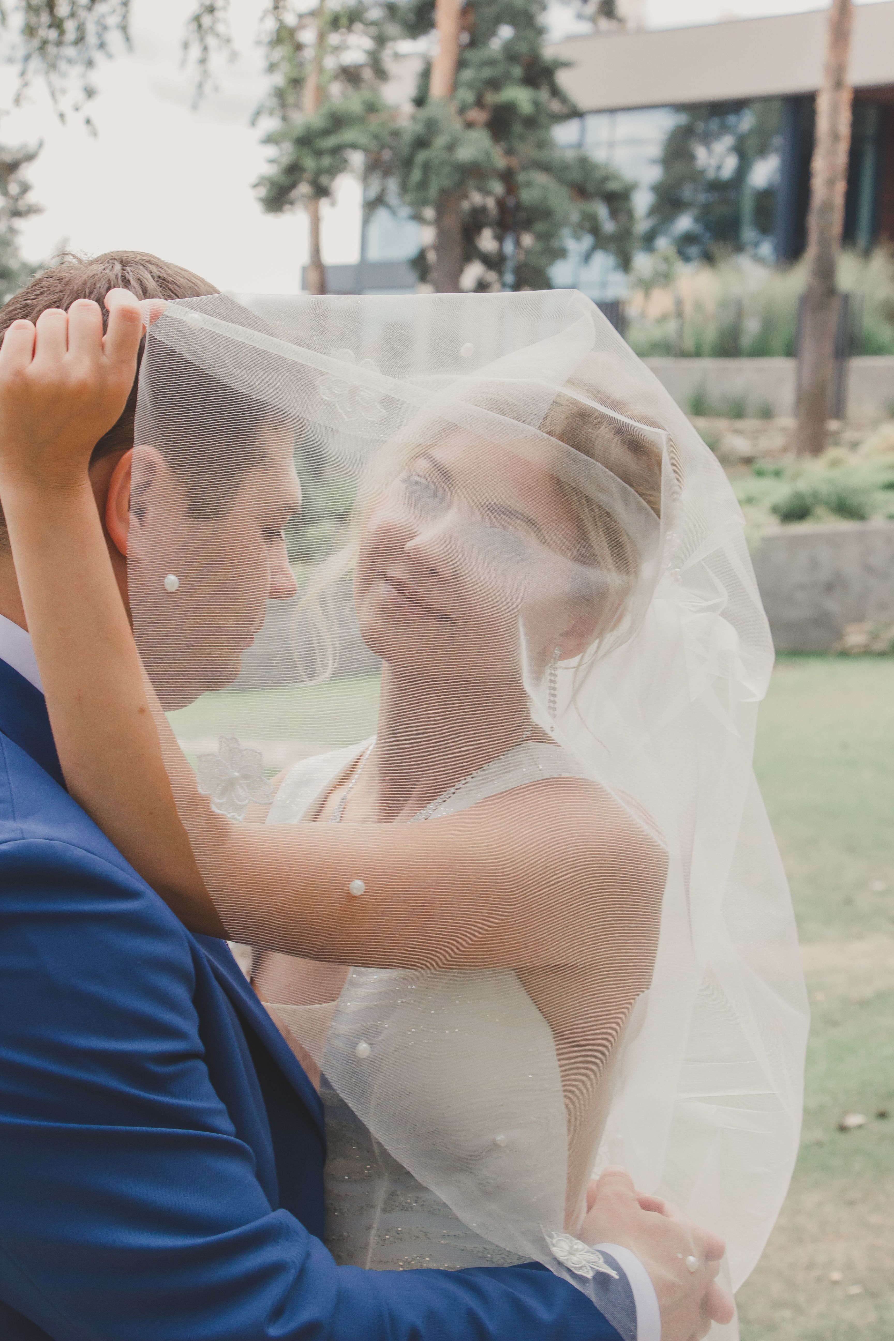 Bride Putting Veil Around her Groom · Free Stock Photo