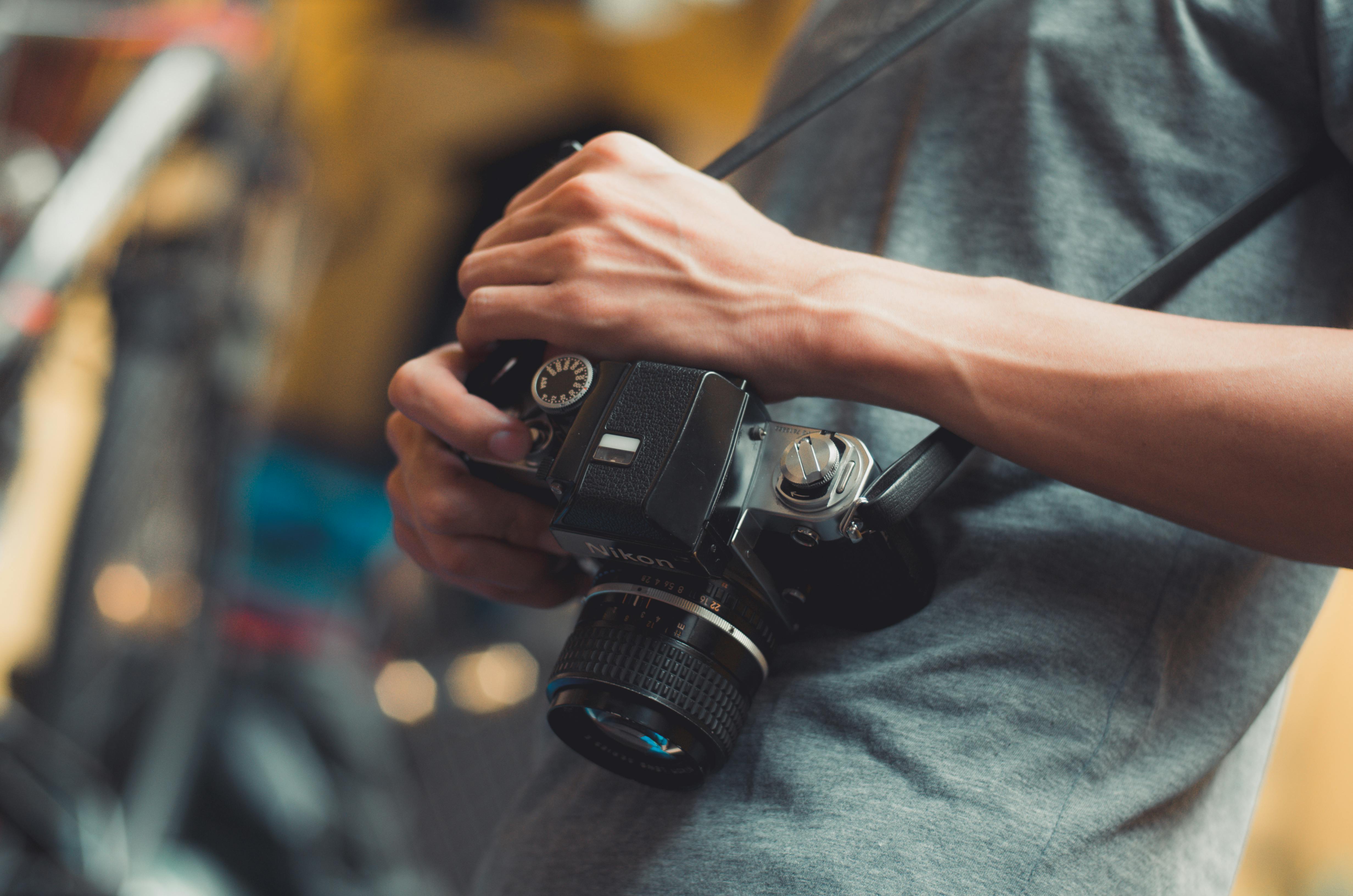 Person Holding Black SLR Camera · Free Stock Photo