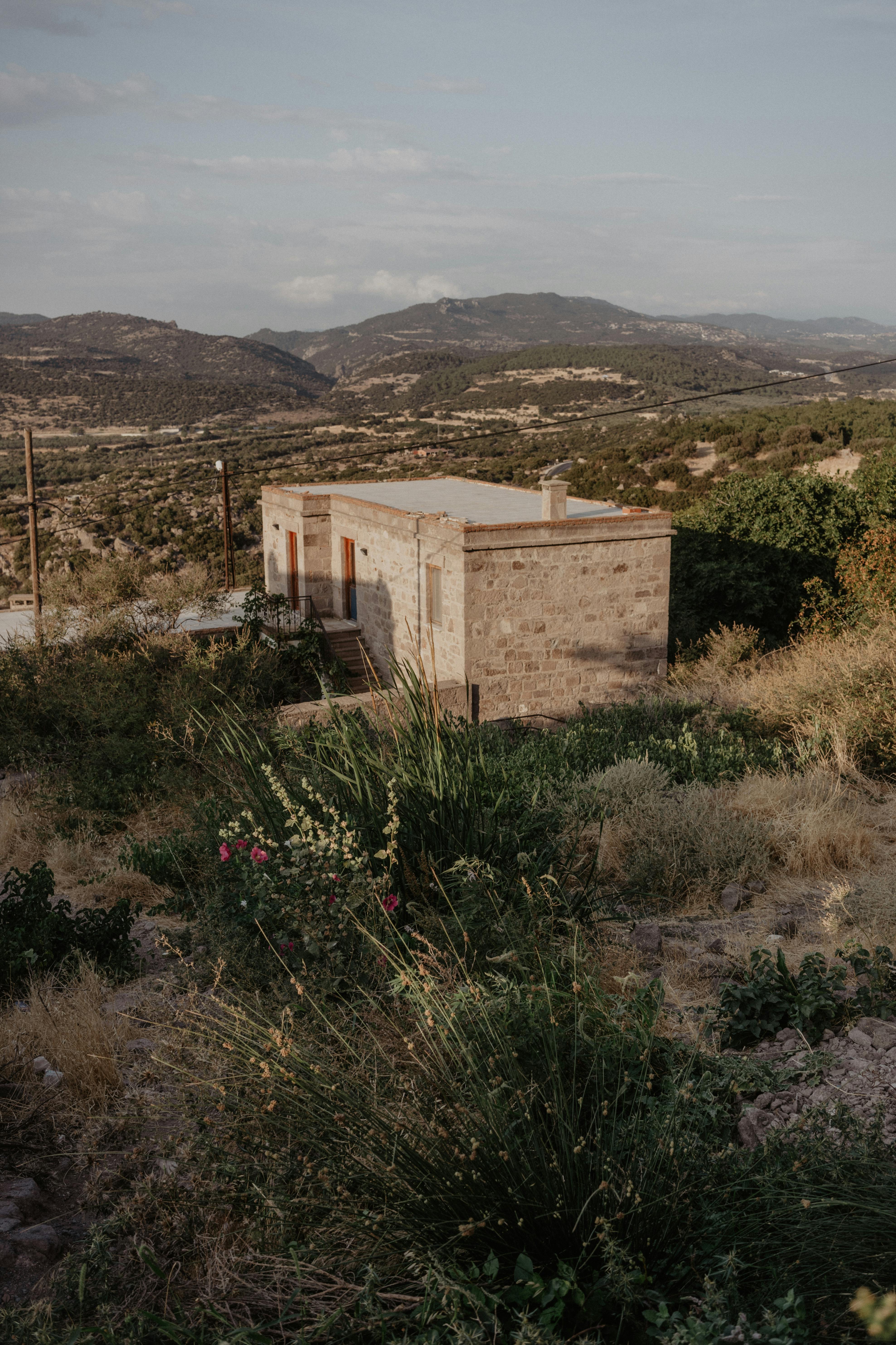 Cinder Block Building in a Valley Overgrown with Shrubs · Free Stock Photo