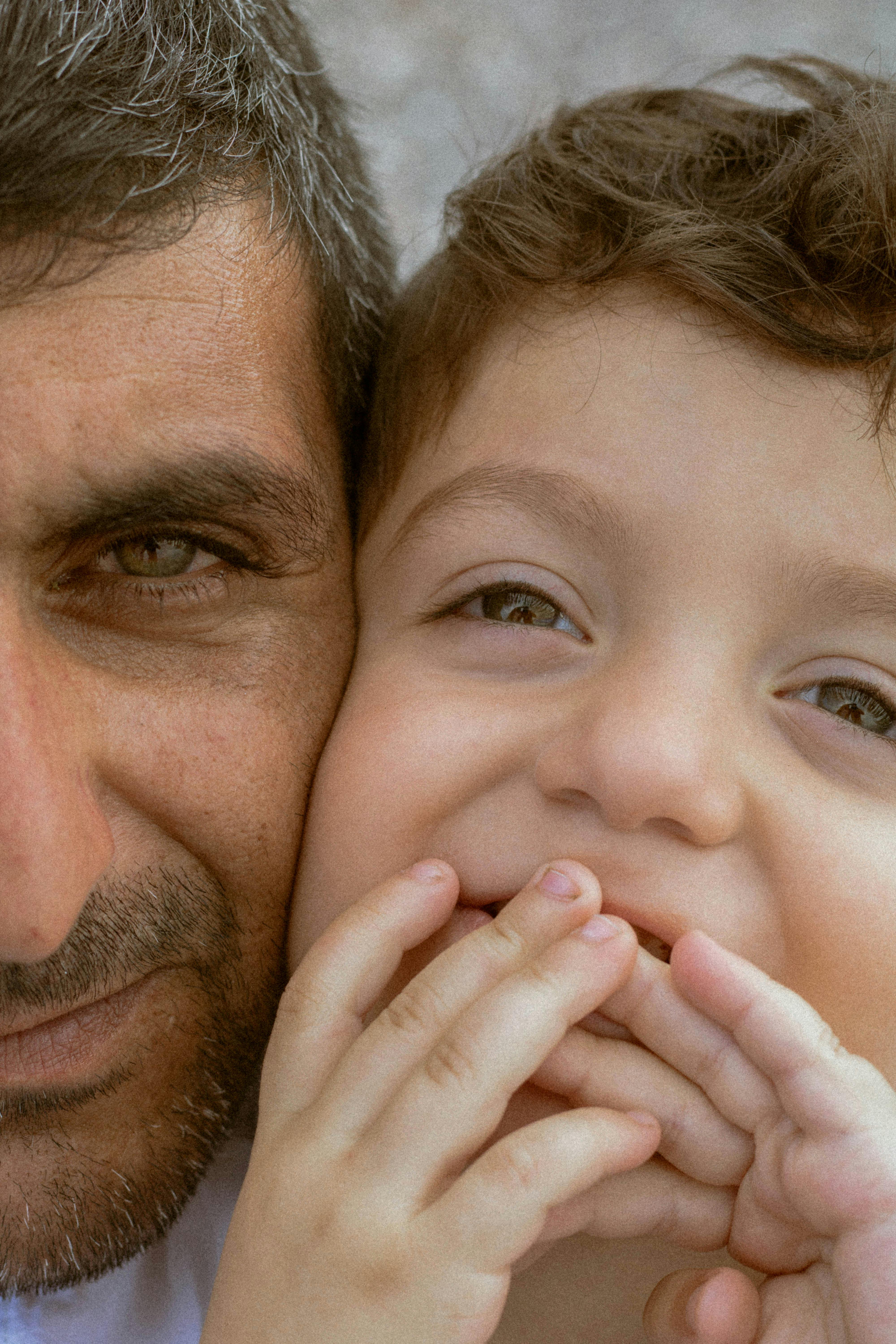 Father with little child resting on rocky cliff near lake in forest ...
