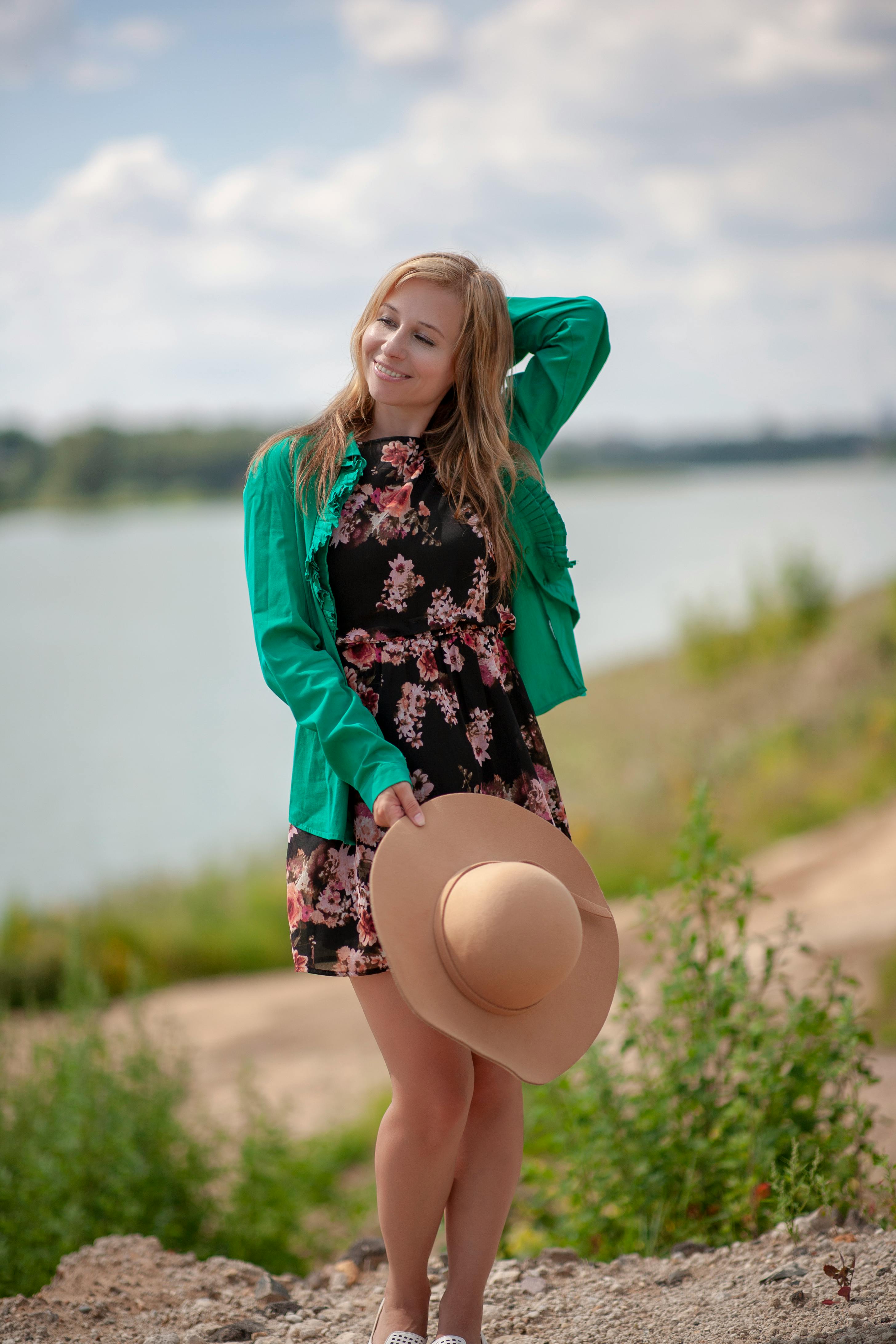 Woman in Black Fixing Hat on her Head · Free Stock Photo