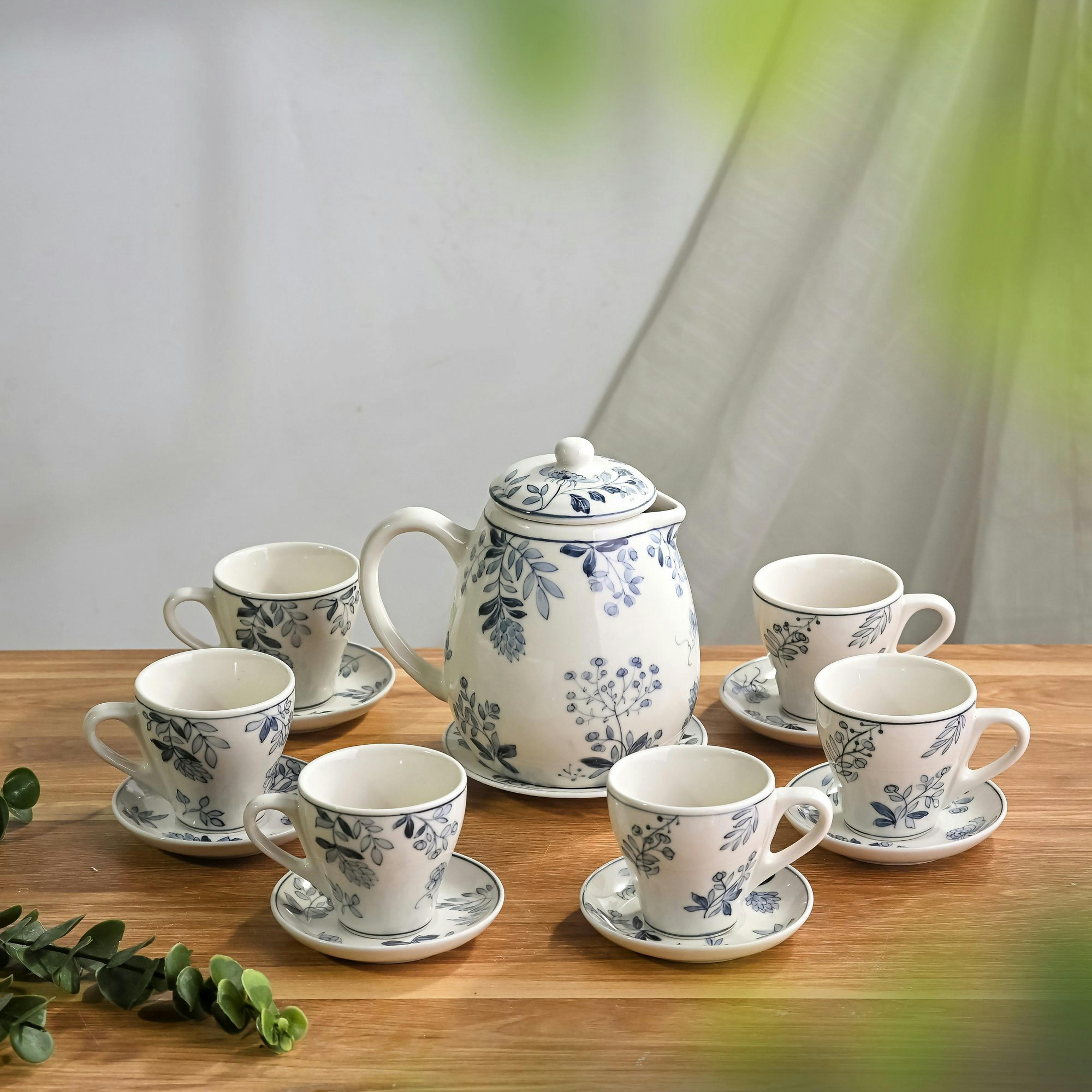 Blue and White Floral Ceramic Teacup and Teapot on Brown Wooden Table ...