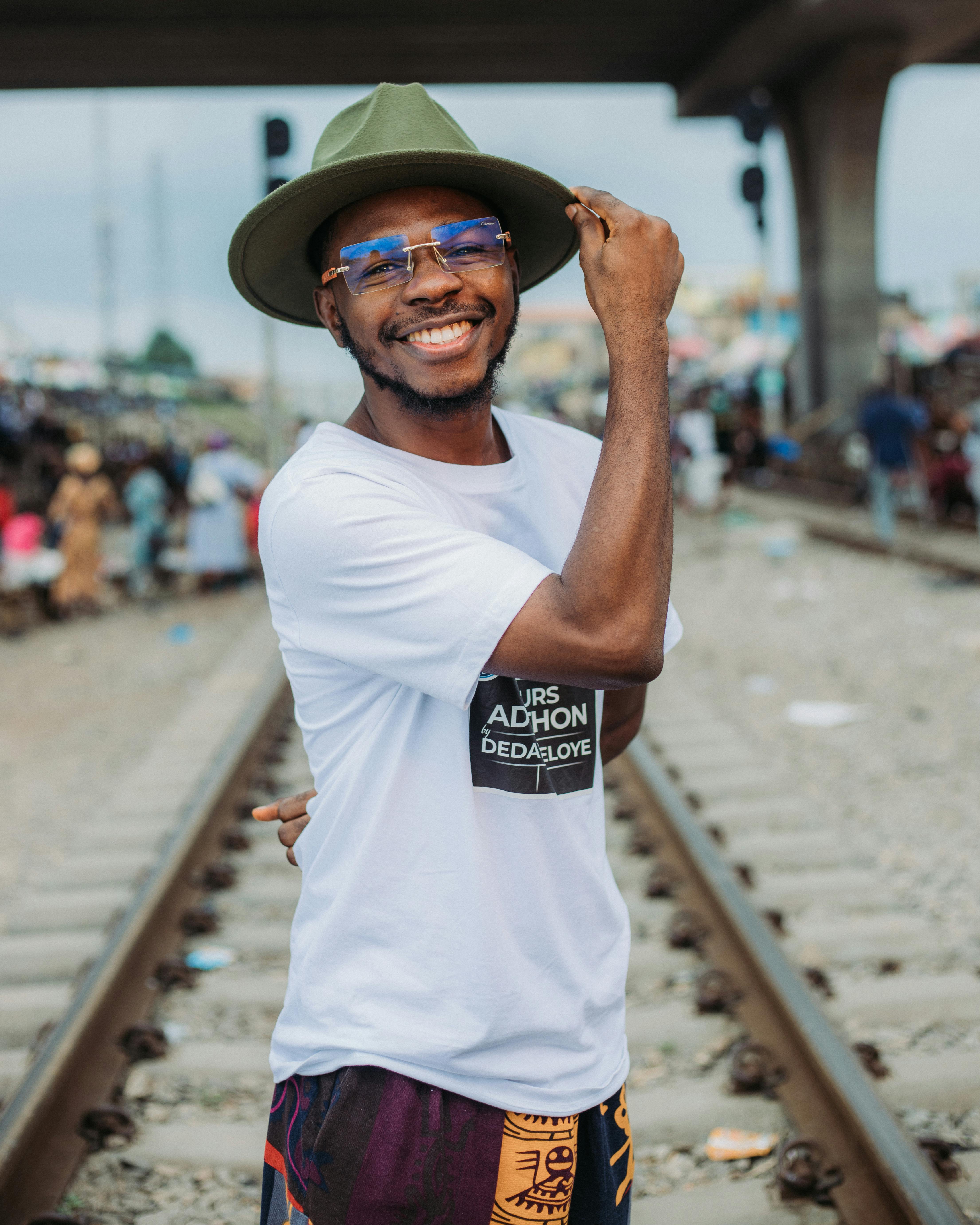 Smiling Man Standing on Train Tracks · Free Stock Photo