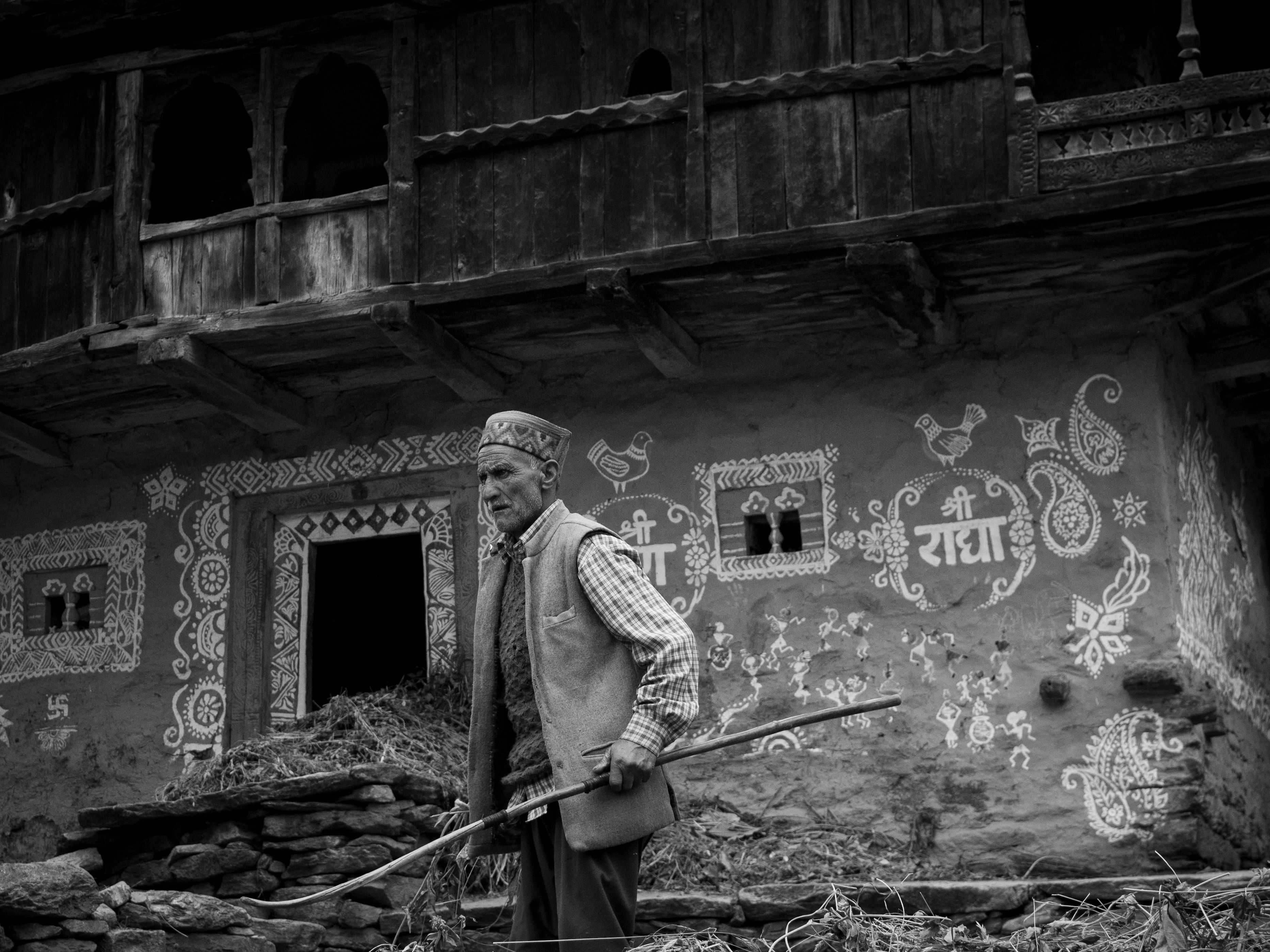 Old Man near Ornate Traditional House · Free Stock Photo