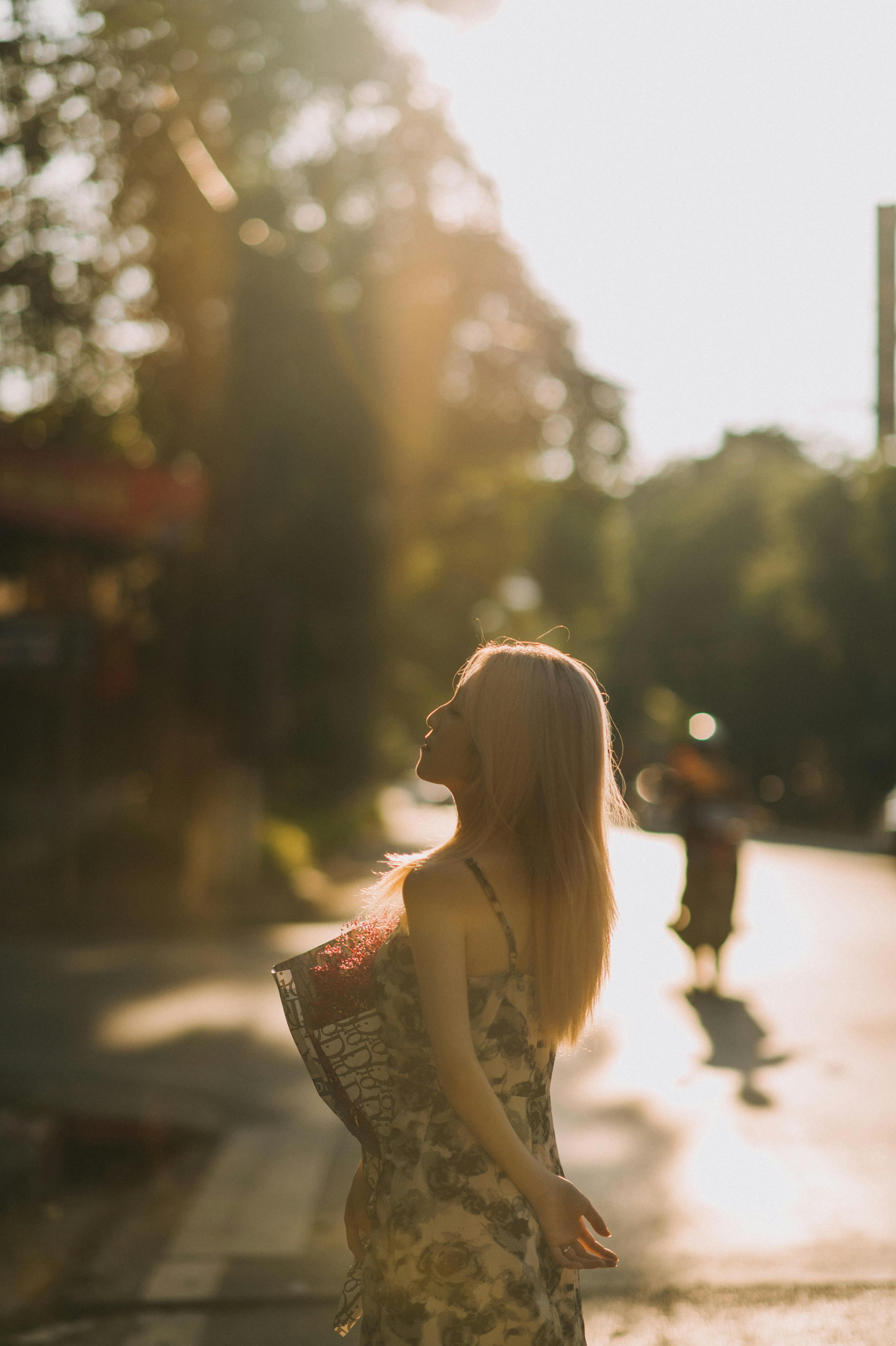 Woman Standing in Sunlight on the Pavement · Free Stock Photo