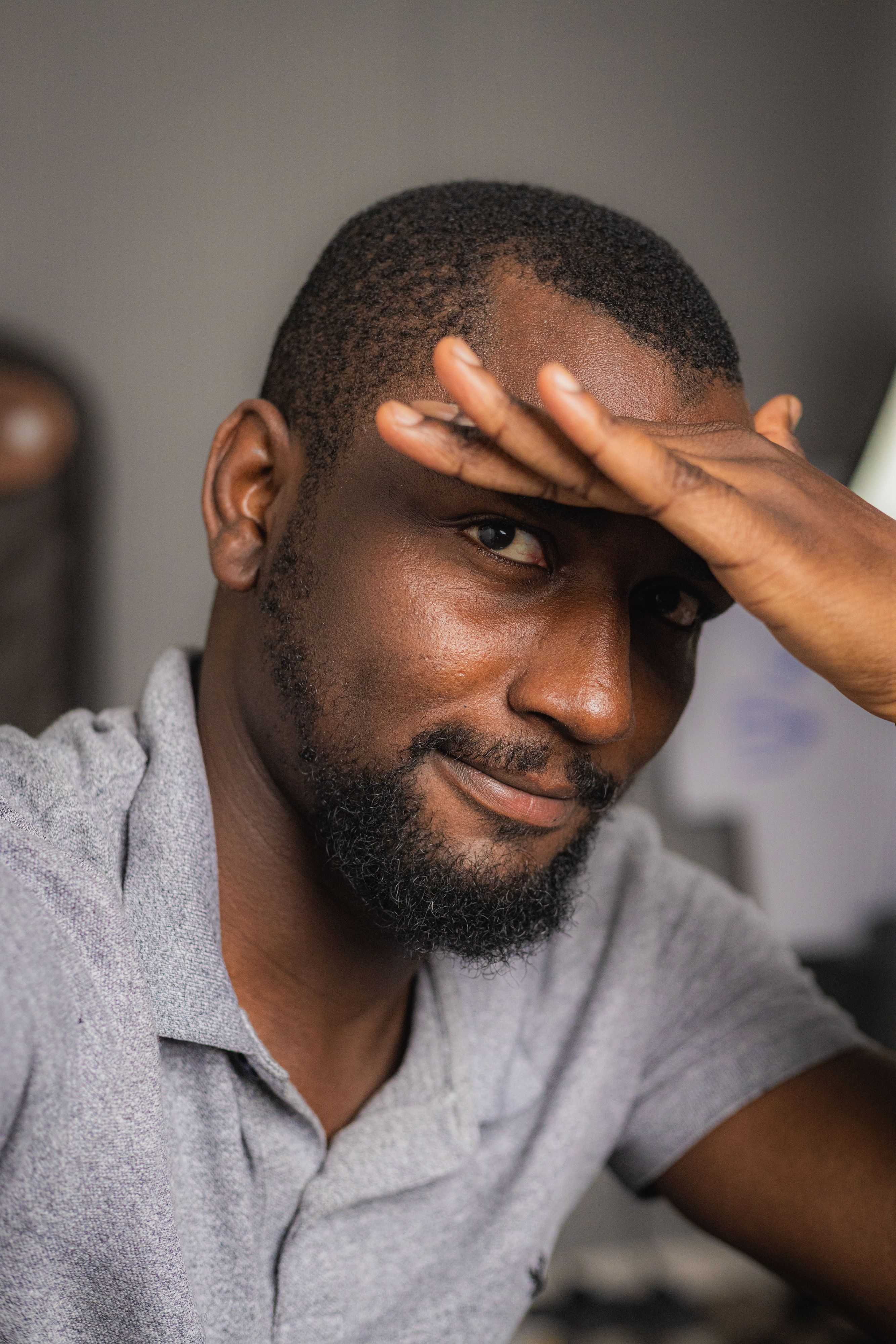 Smiling Man with Hand on Forehead · Free Stock Photo