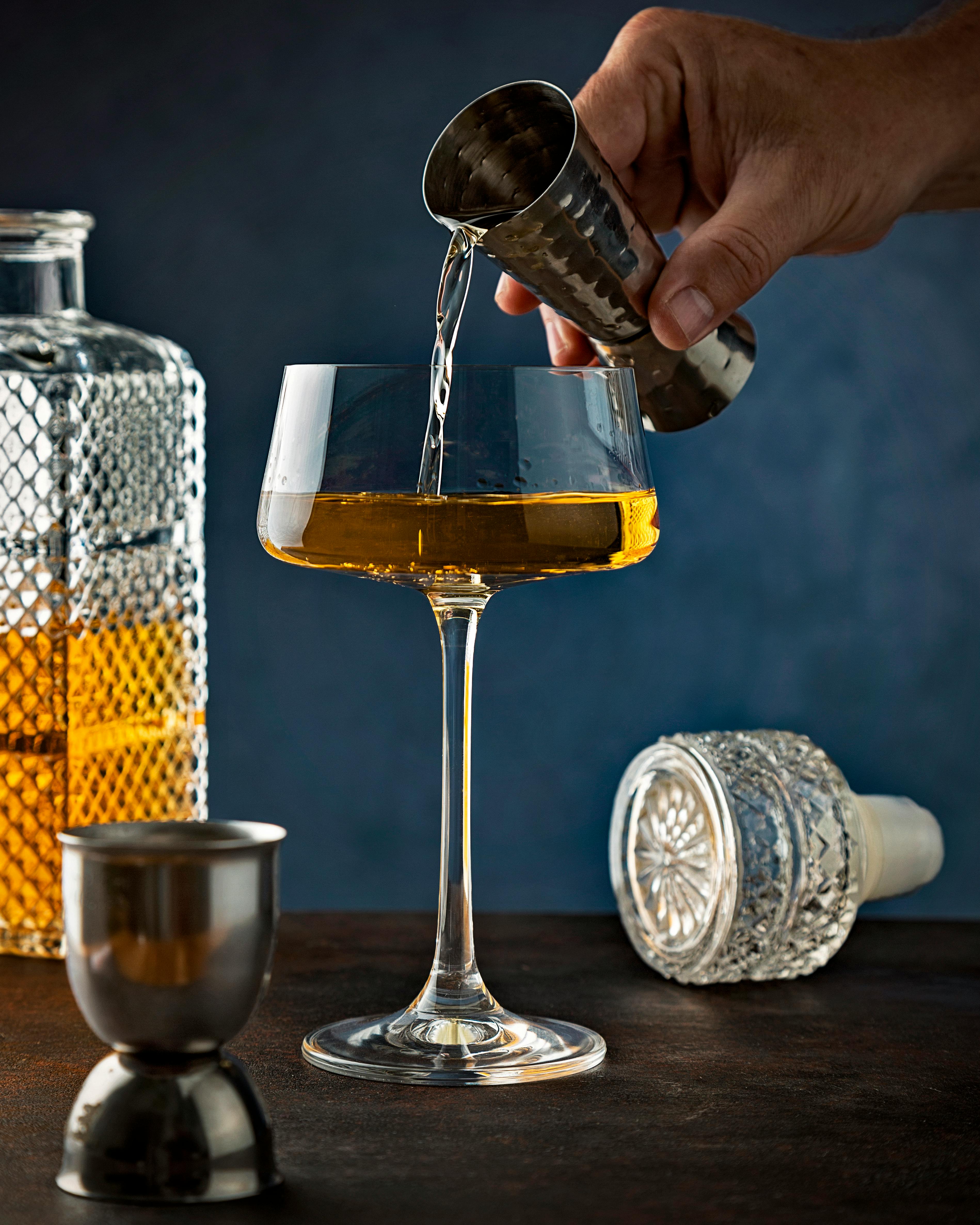 A Hand Pouring Liquid to the Glass · Free Stock Photo