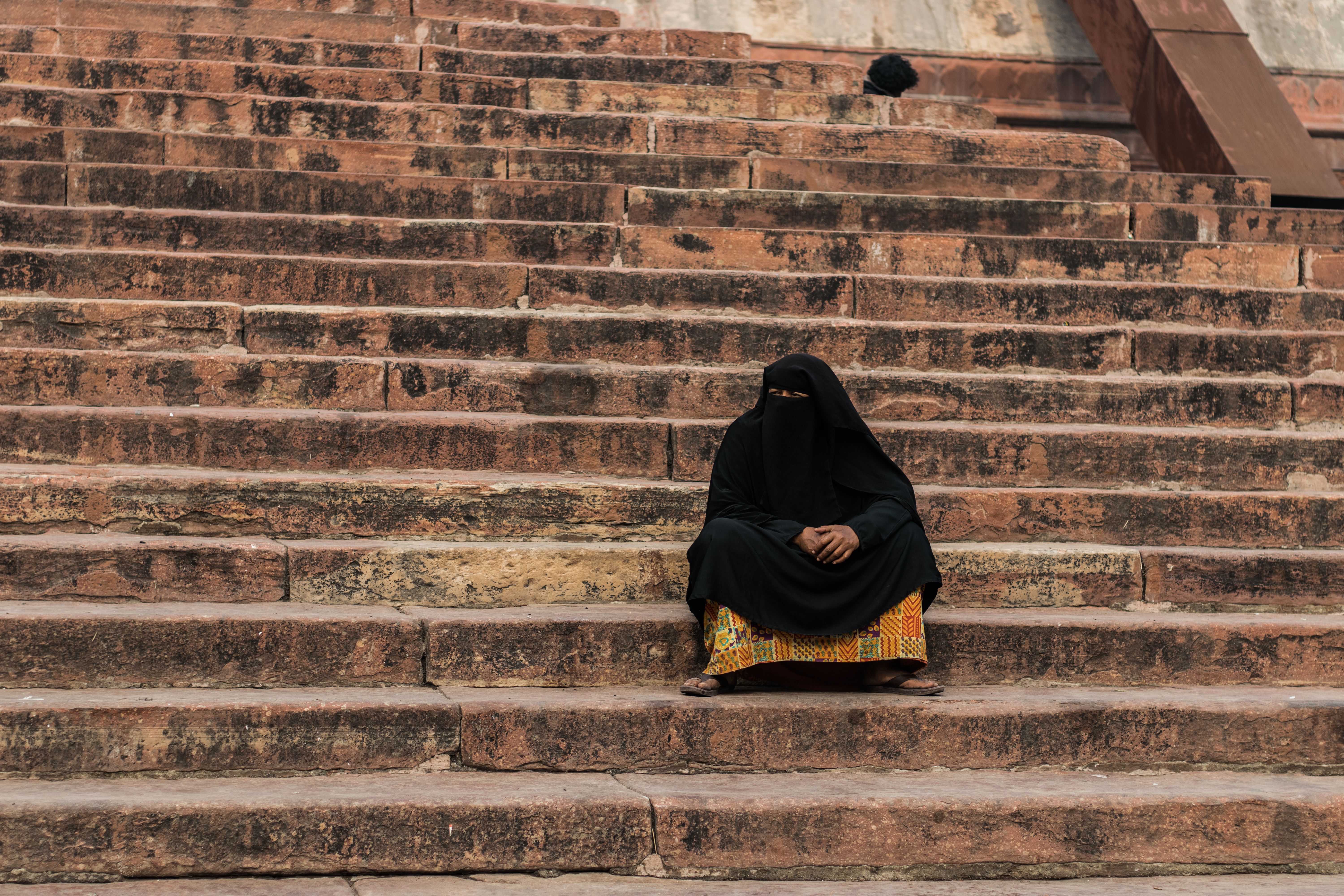 Woman in Niqab and Abaya Sitting on Stairs · Free Stock Photo