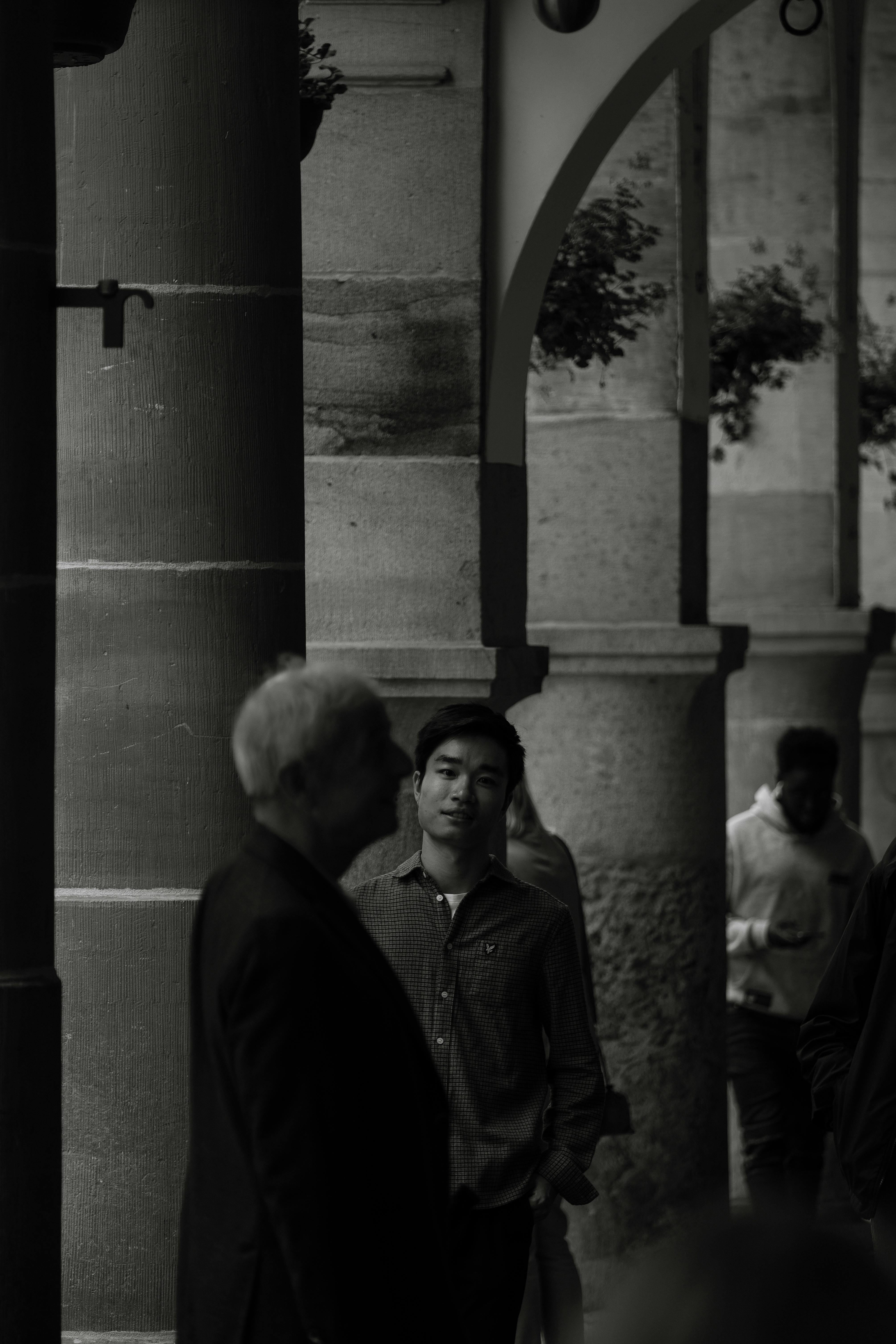 People Standing near Columns in Black and White · Free Stock Photo