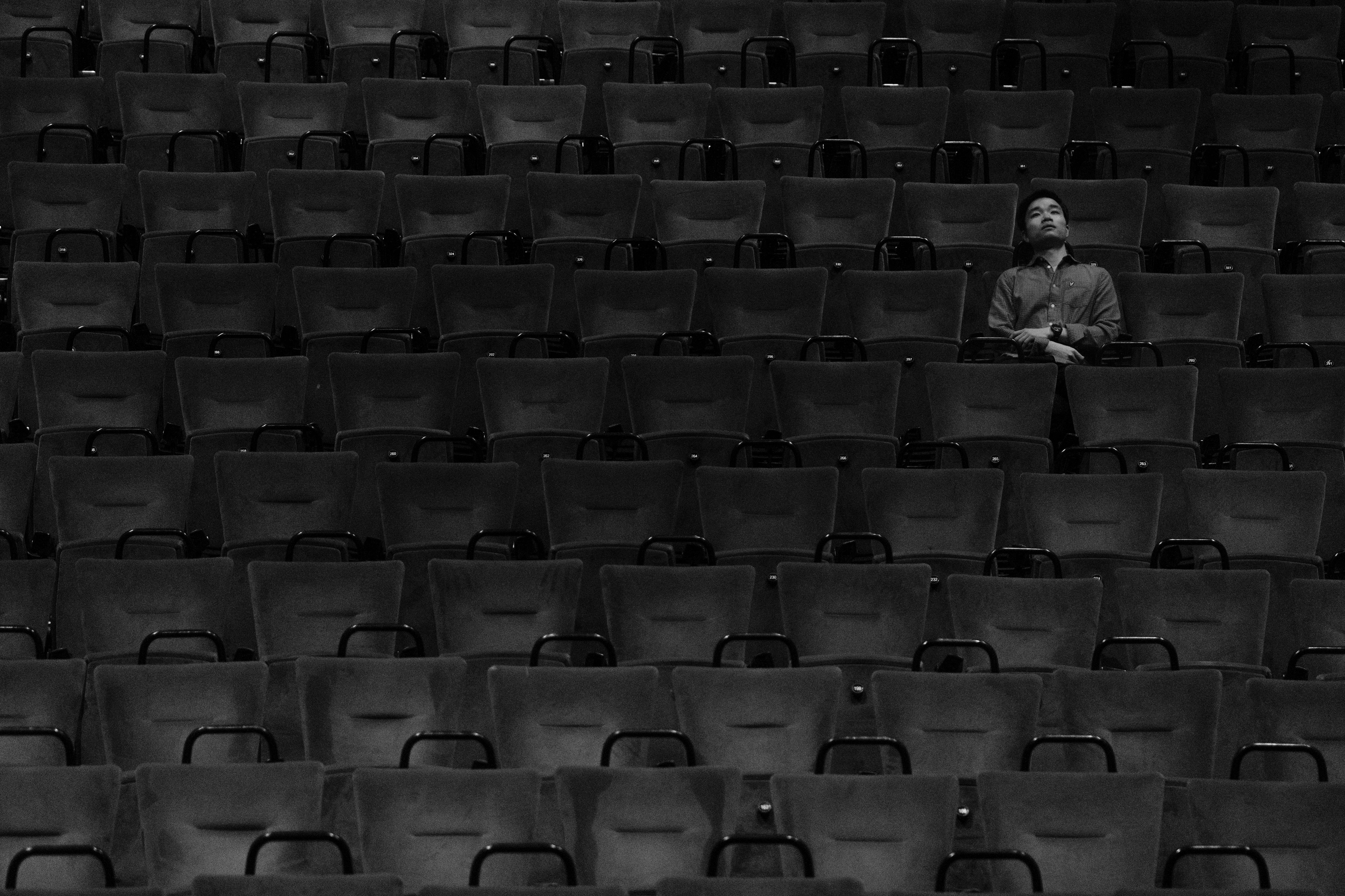 Man Sitting in Empty Concert Hall · Free Stock Photo