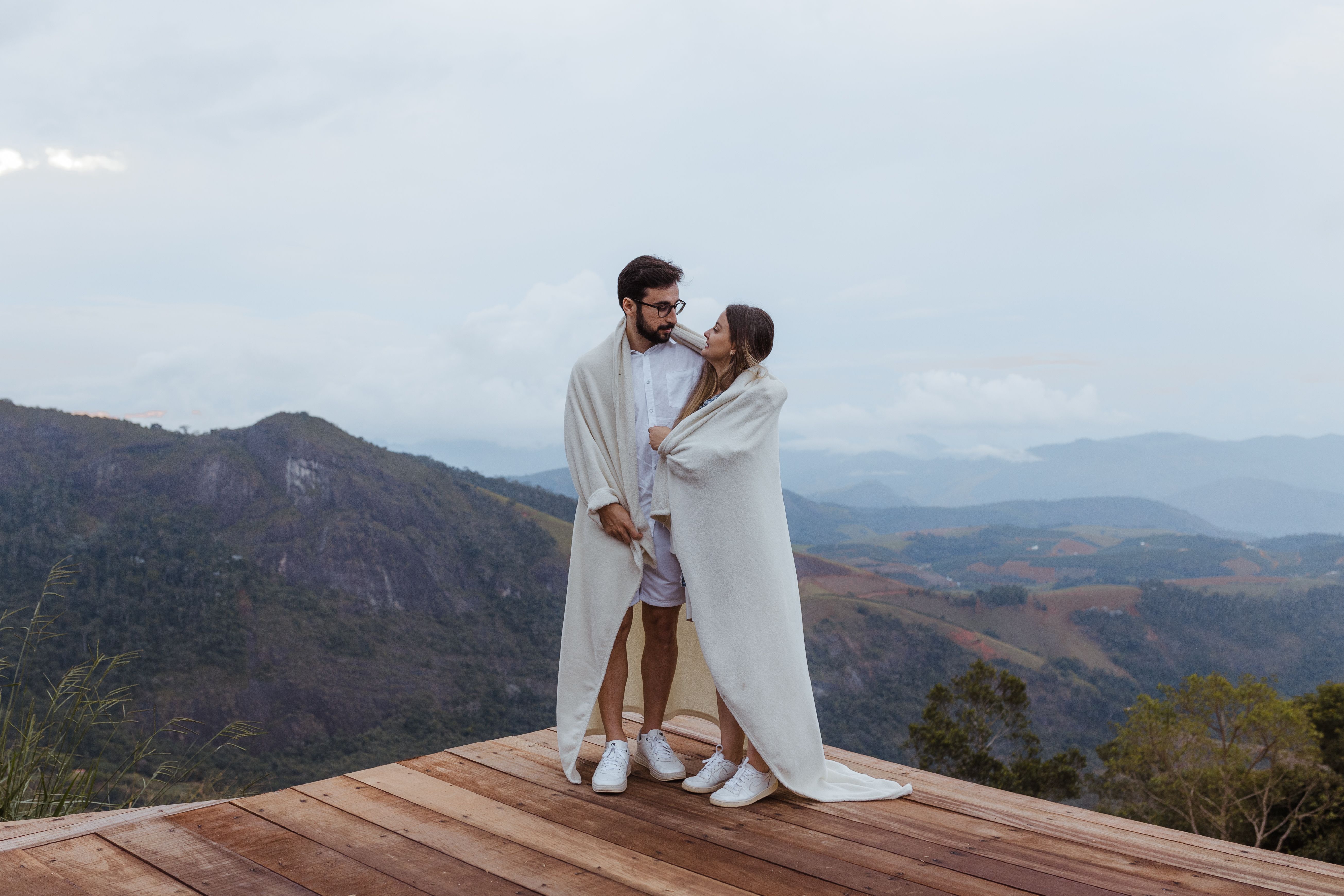 Loving Couple Wrapped in Blanket Posing on Terrace · Free Stock Photo