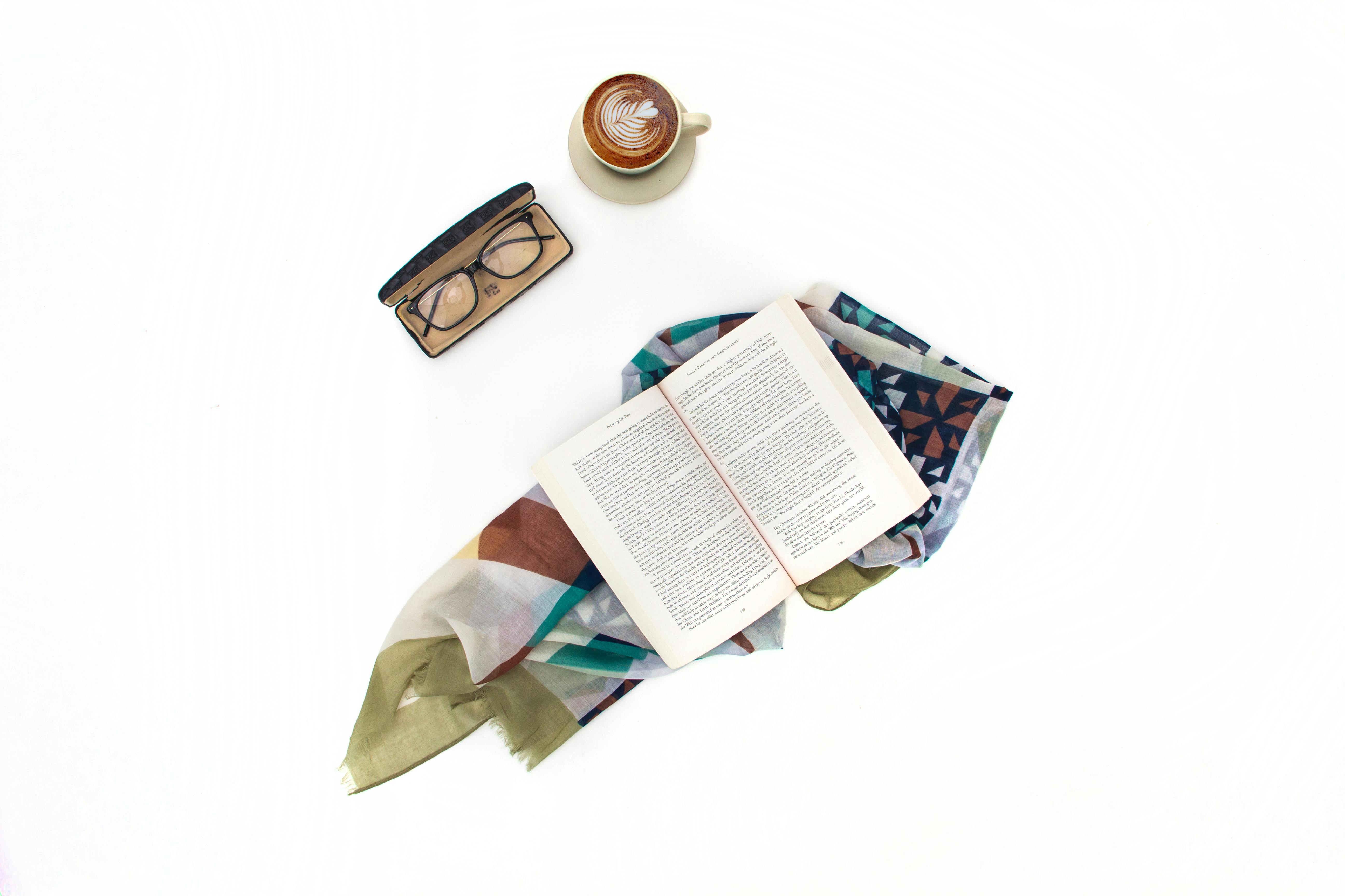 Composition of opened book cup of coffee and eyeglasses in case · Free ...