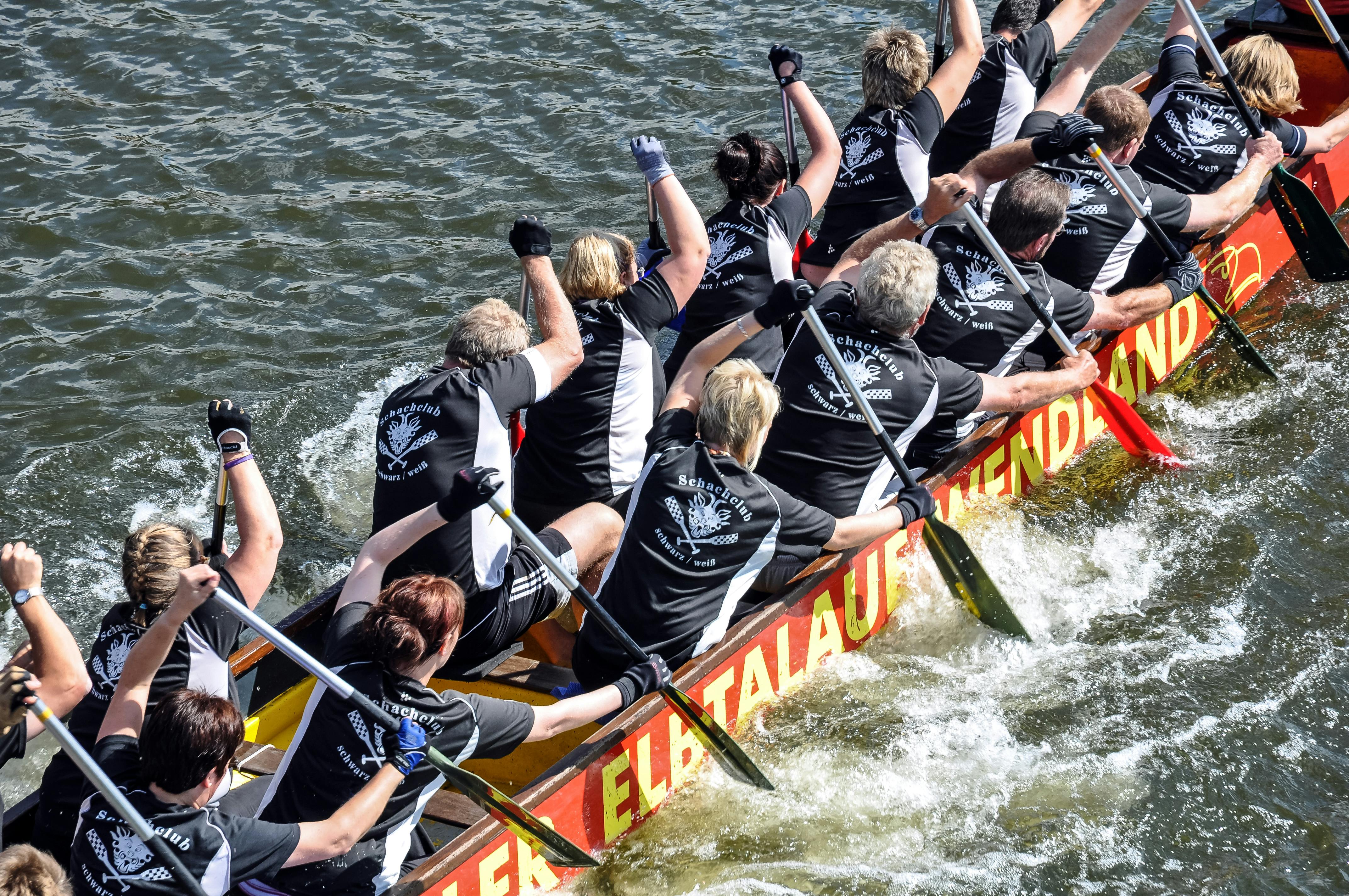 Group of People Rowing in a Race Boat · Free Stock Photo