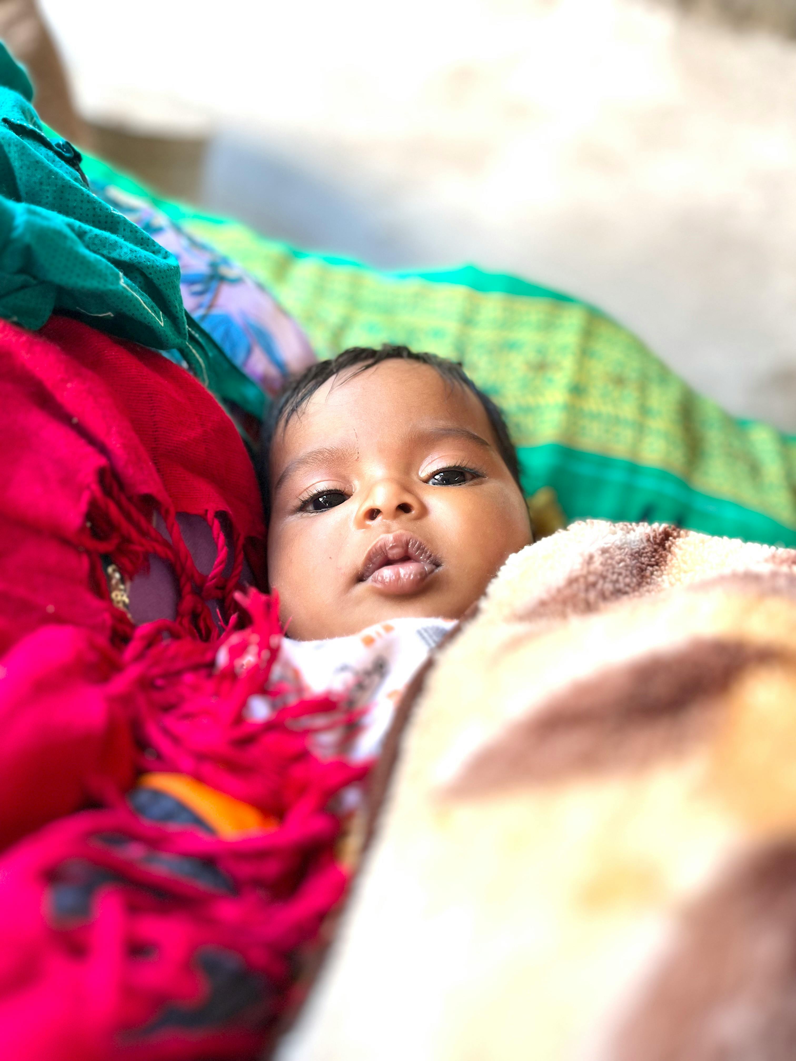 Ethnic child covering half of face with blanket lying in bed · Free ...
