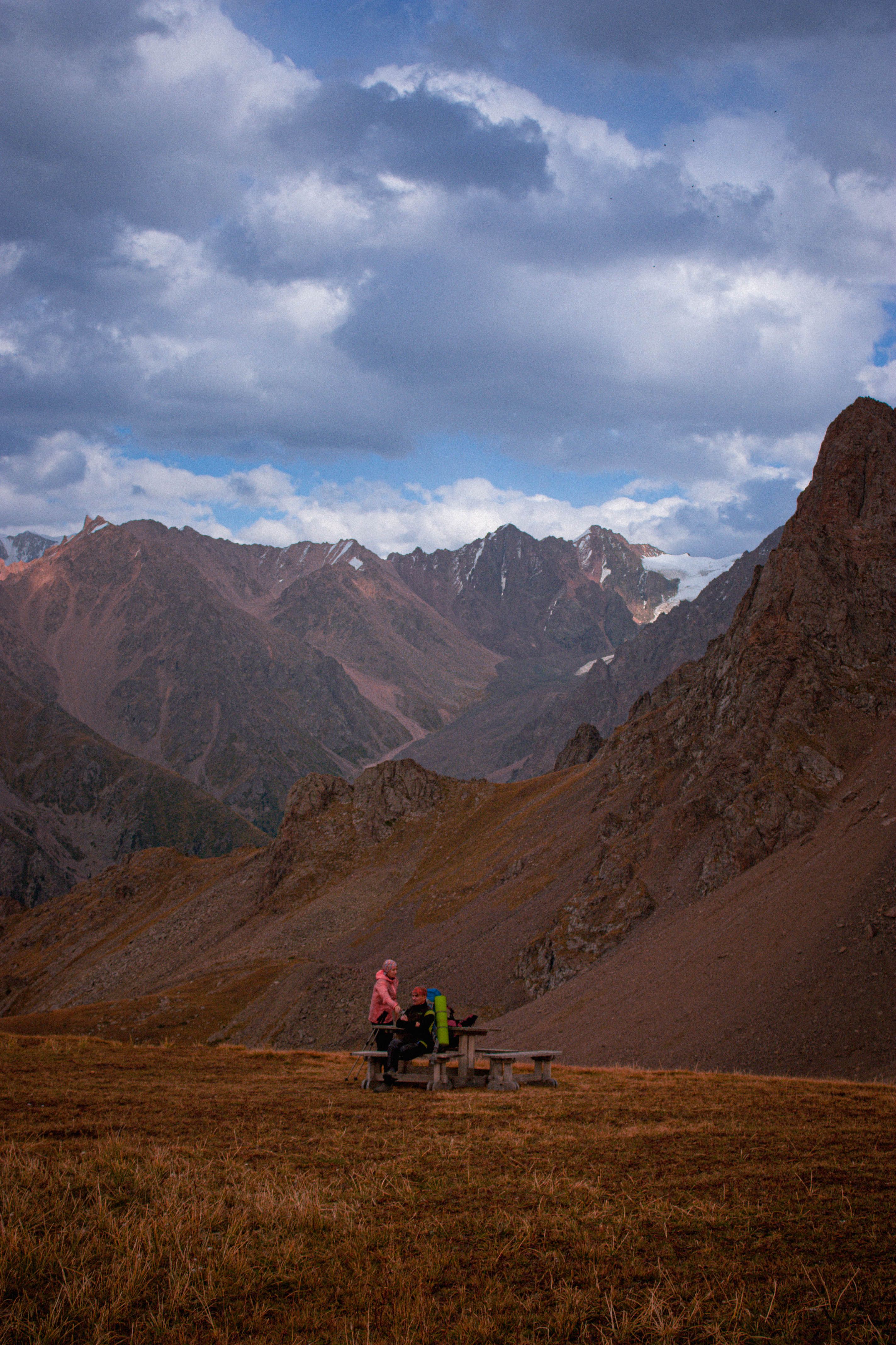 Hikers at Picnic Table in Mountains · Free Stock Photo