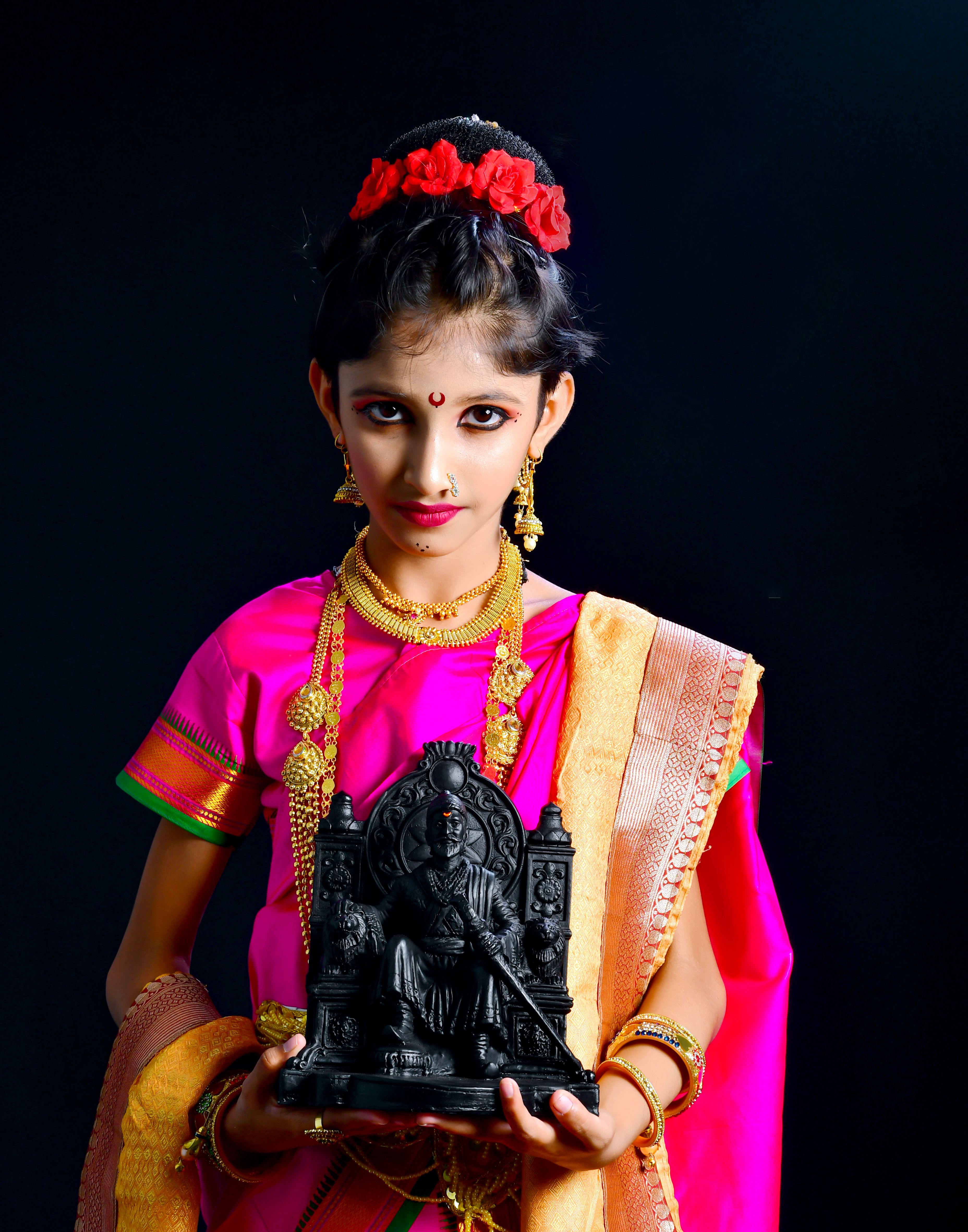 Woman in Traditional Clothing Holding Statue · Free Stock Photo