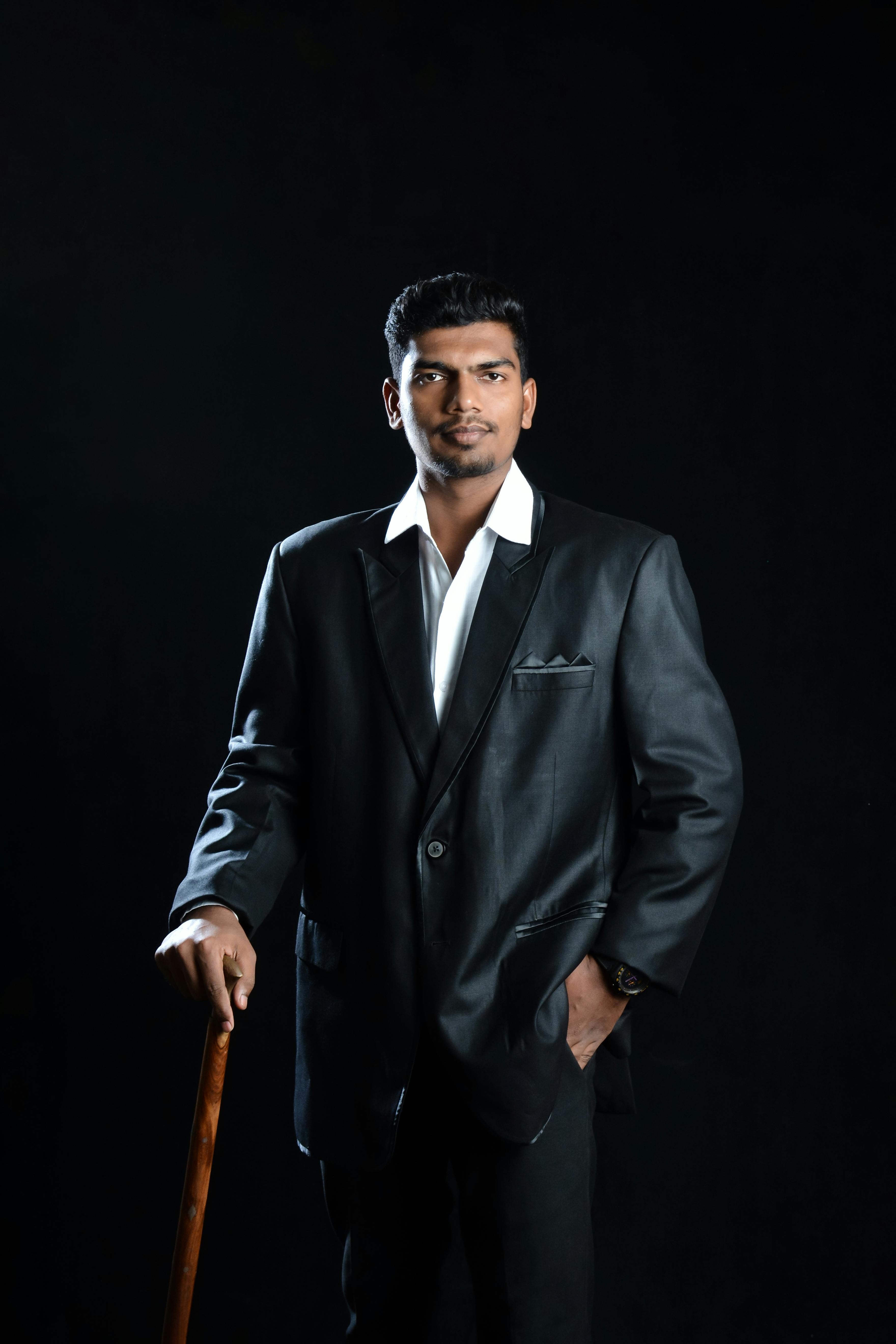 A Man in black formal dress and in hand hold a stick on hand and ...