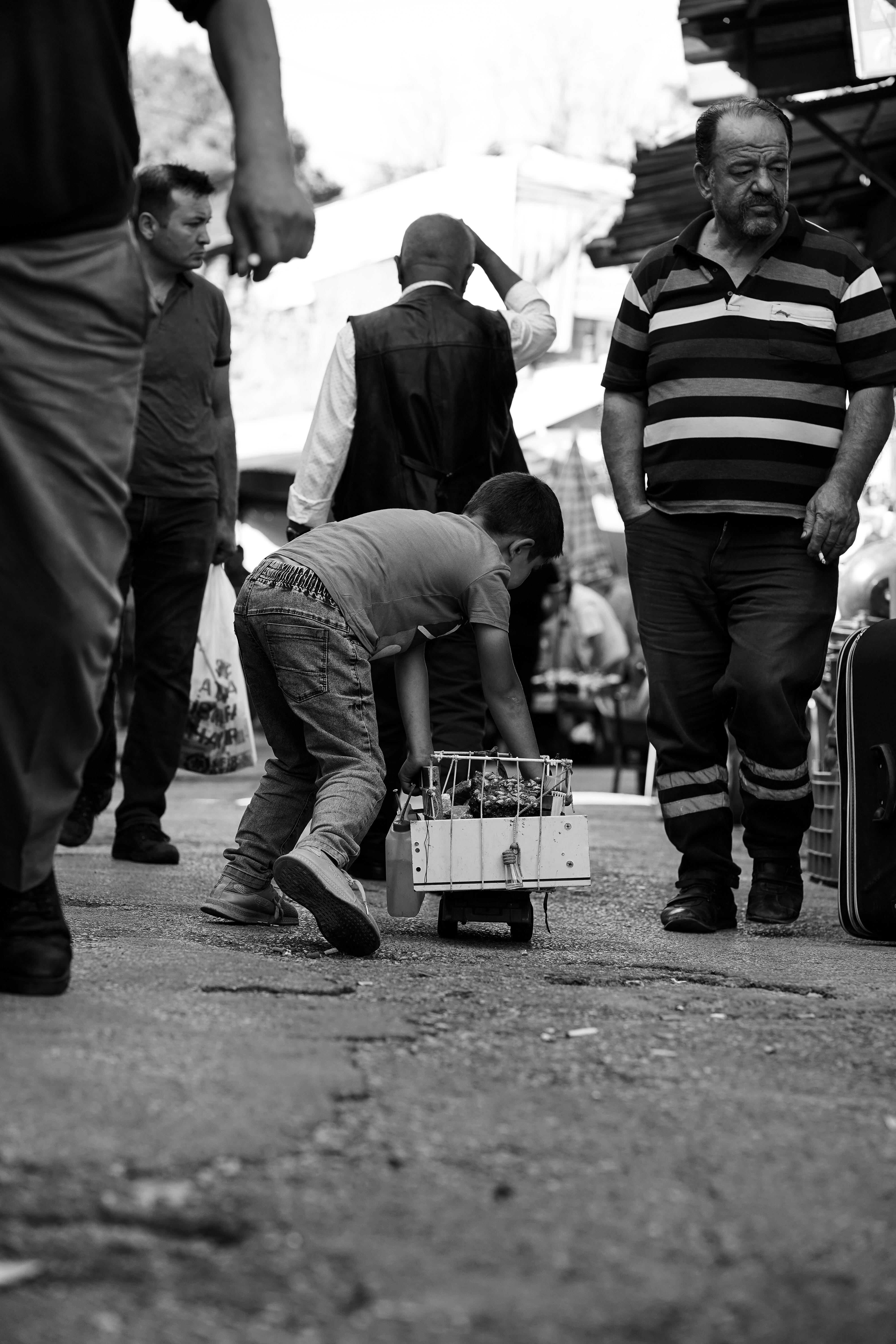 A Boy Pushing a Toy Car on the Street · Free Stock Photo