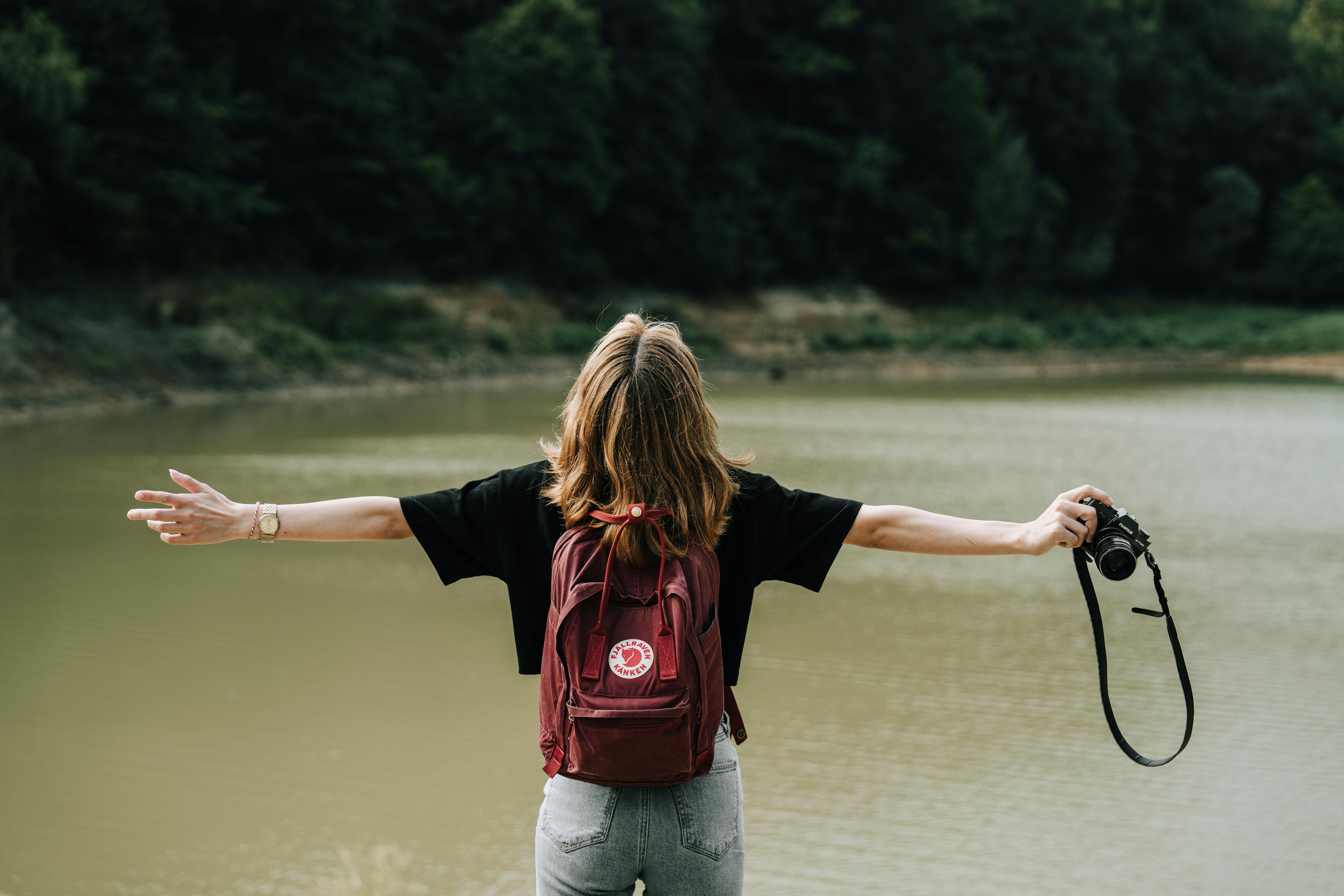 Back View of Woman Standing with Arms Stretched with Lake behind · Free ...
