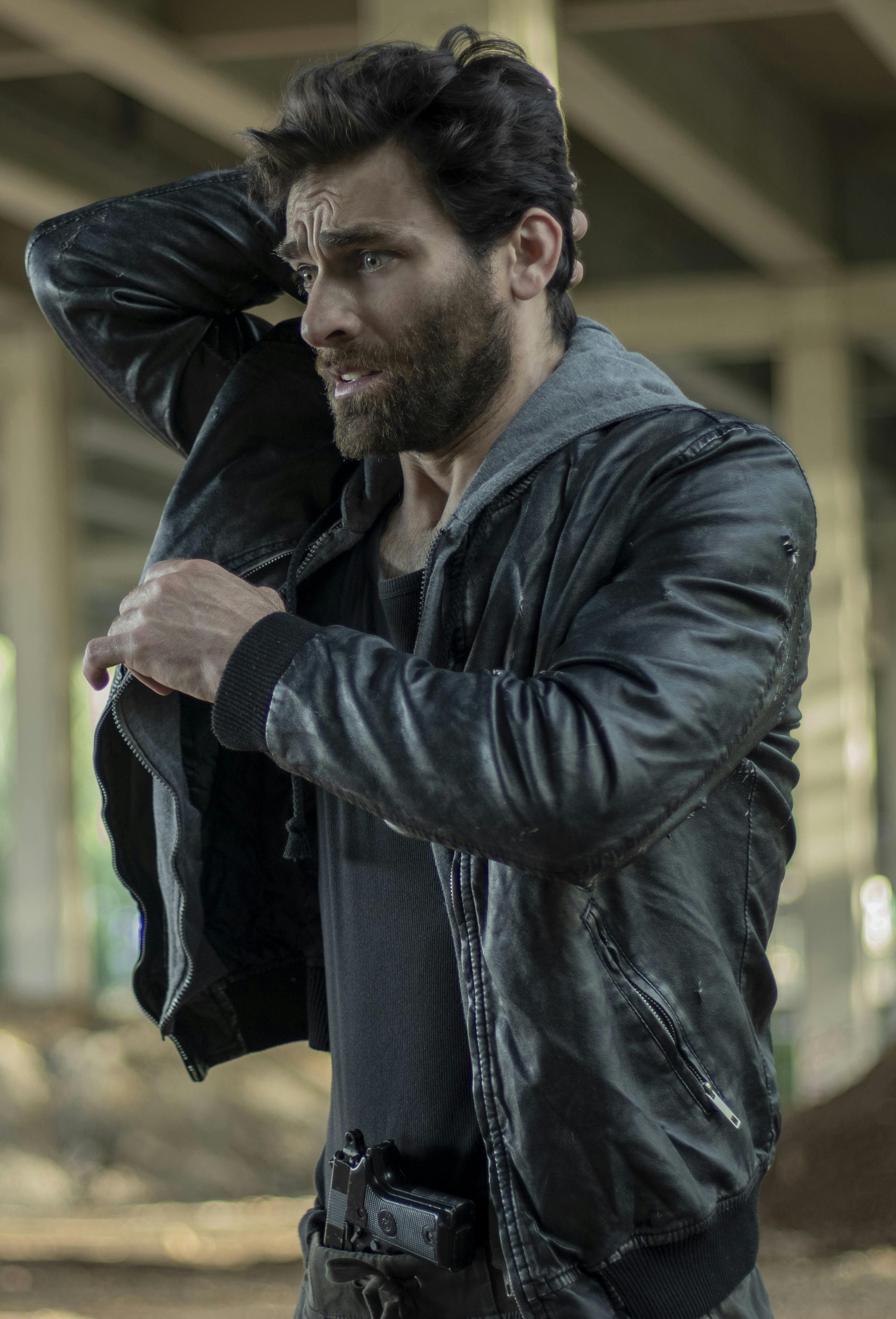 Man Raising Hands Behind His Head with a Gun in Belt · Free Stock Photo