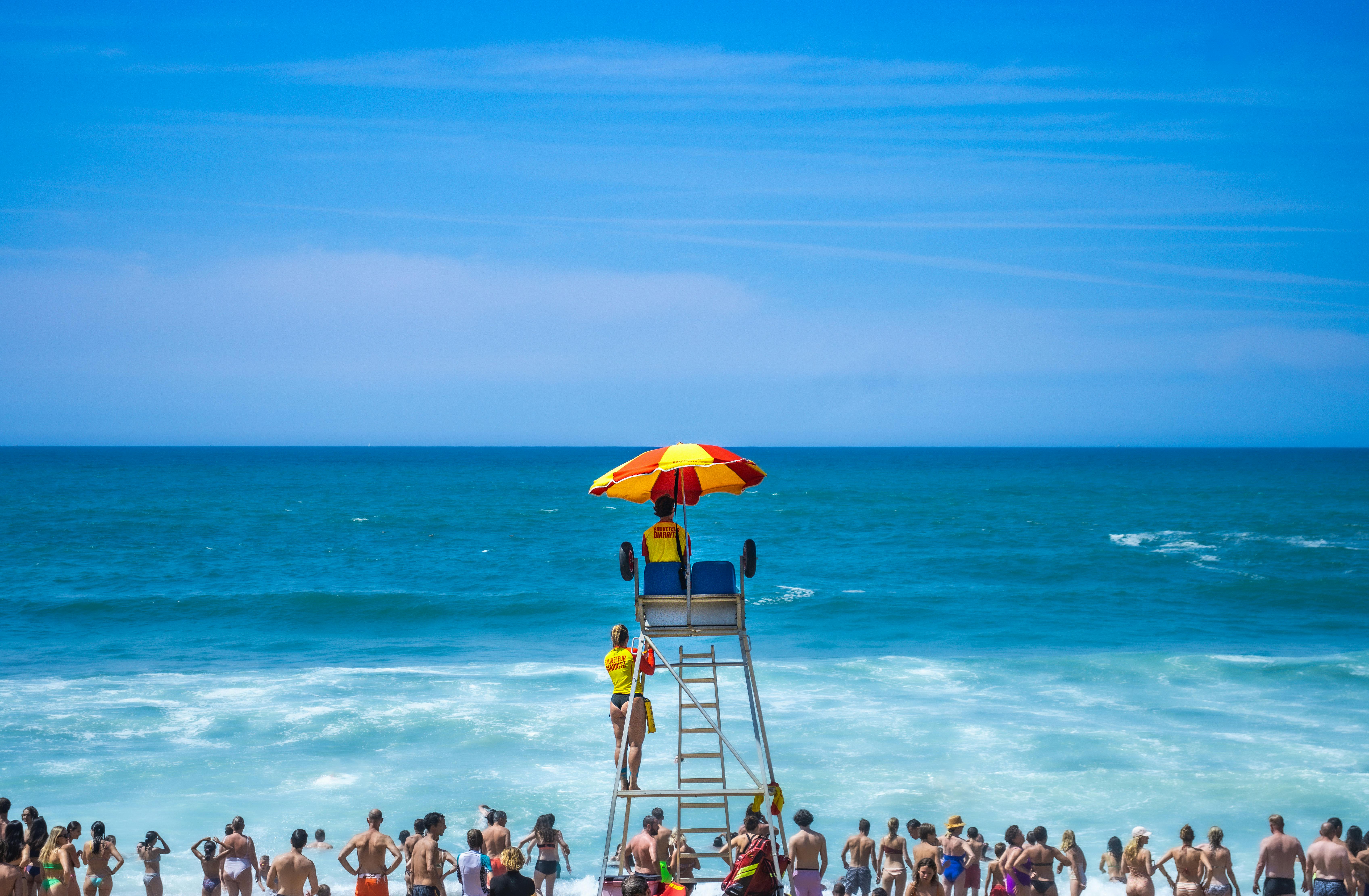 People Near Beach With Lifeguard Gazebo · Free Stock Photo