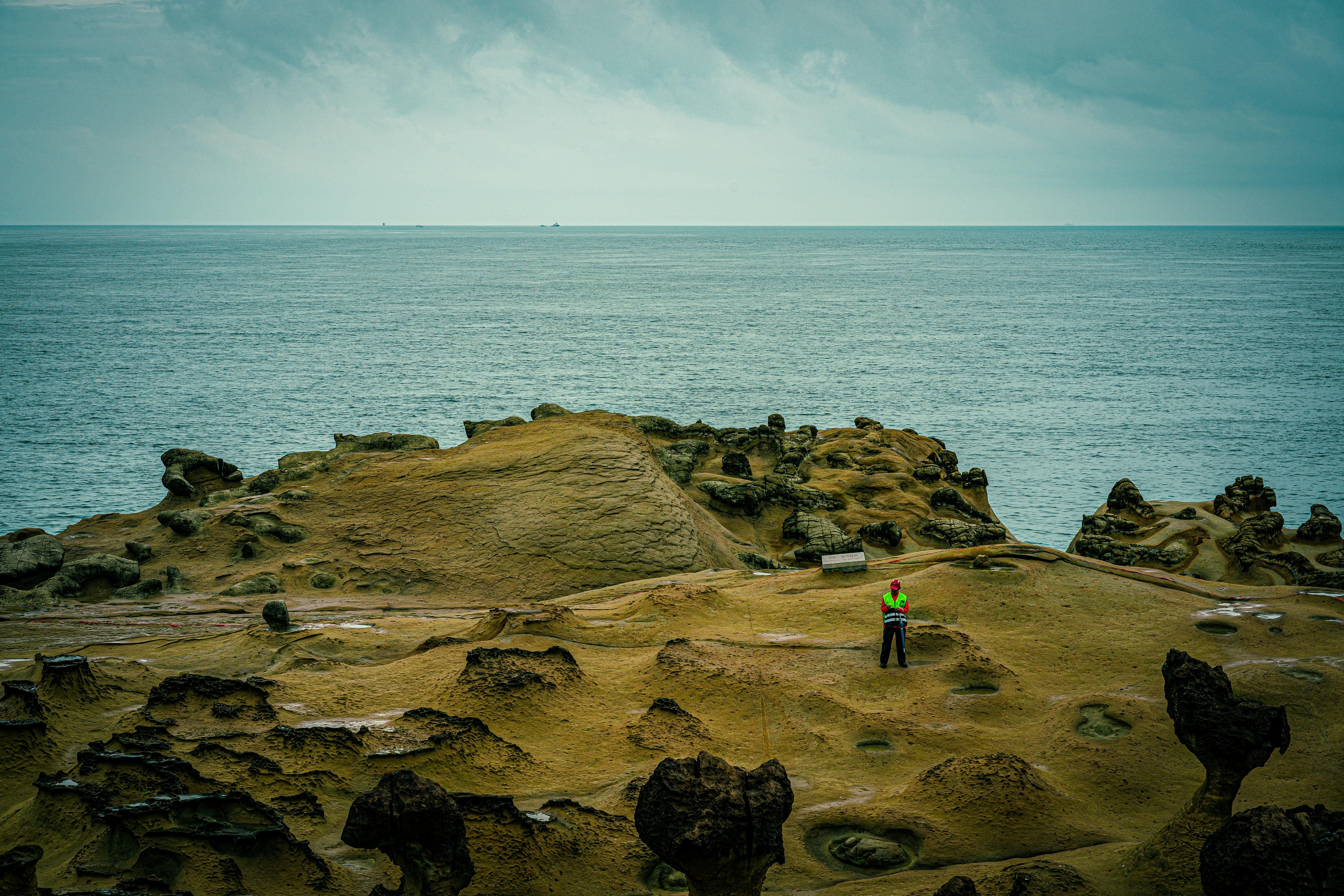 Person Standing atop Eroded Rock Formations in Yehliu Geopark, Taiwan ...