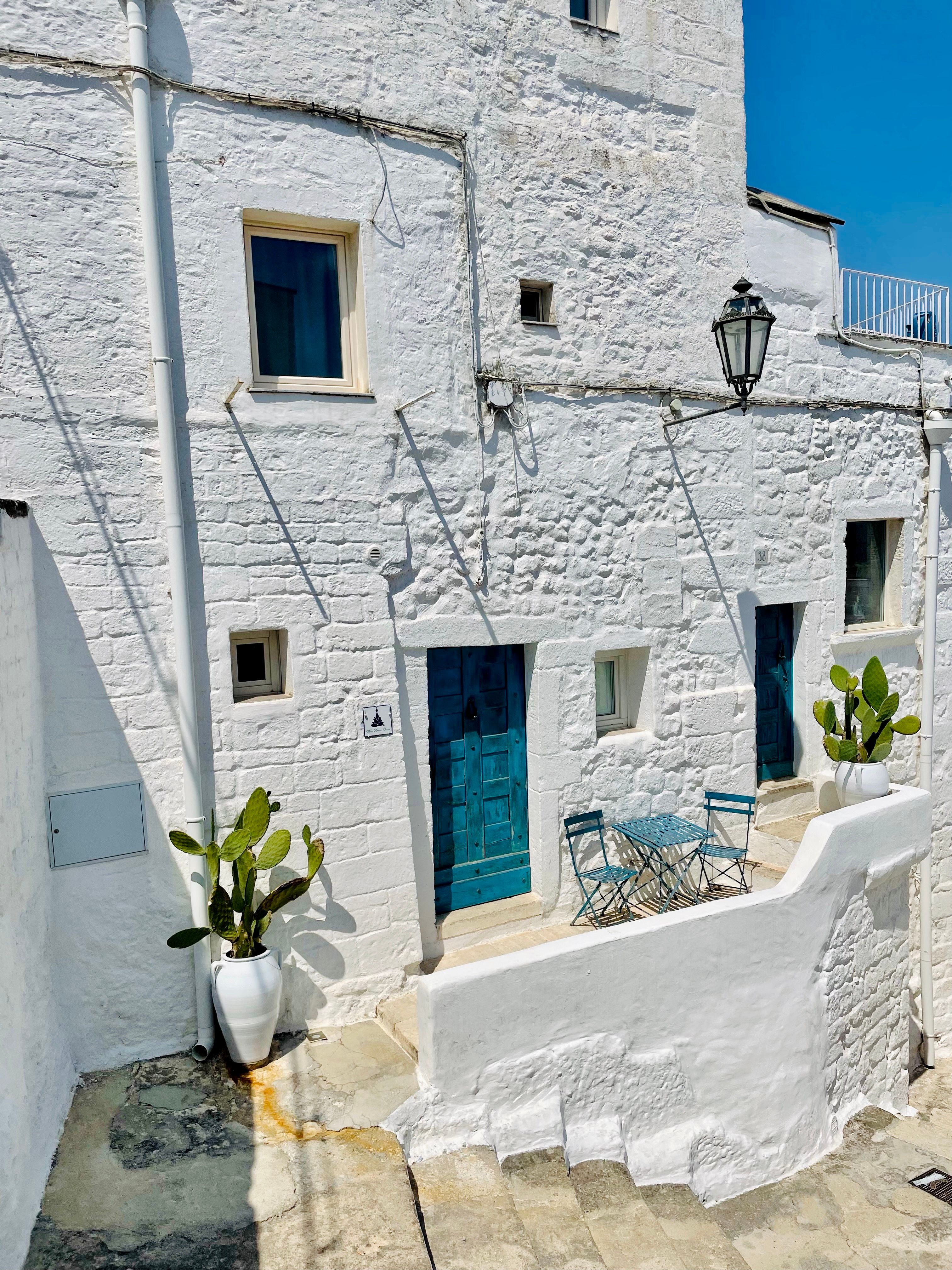 Front of a White Stone House with a Blue Door · Free Stock Photo