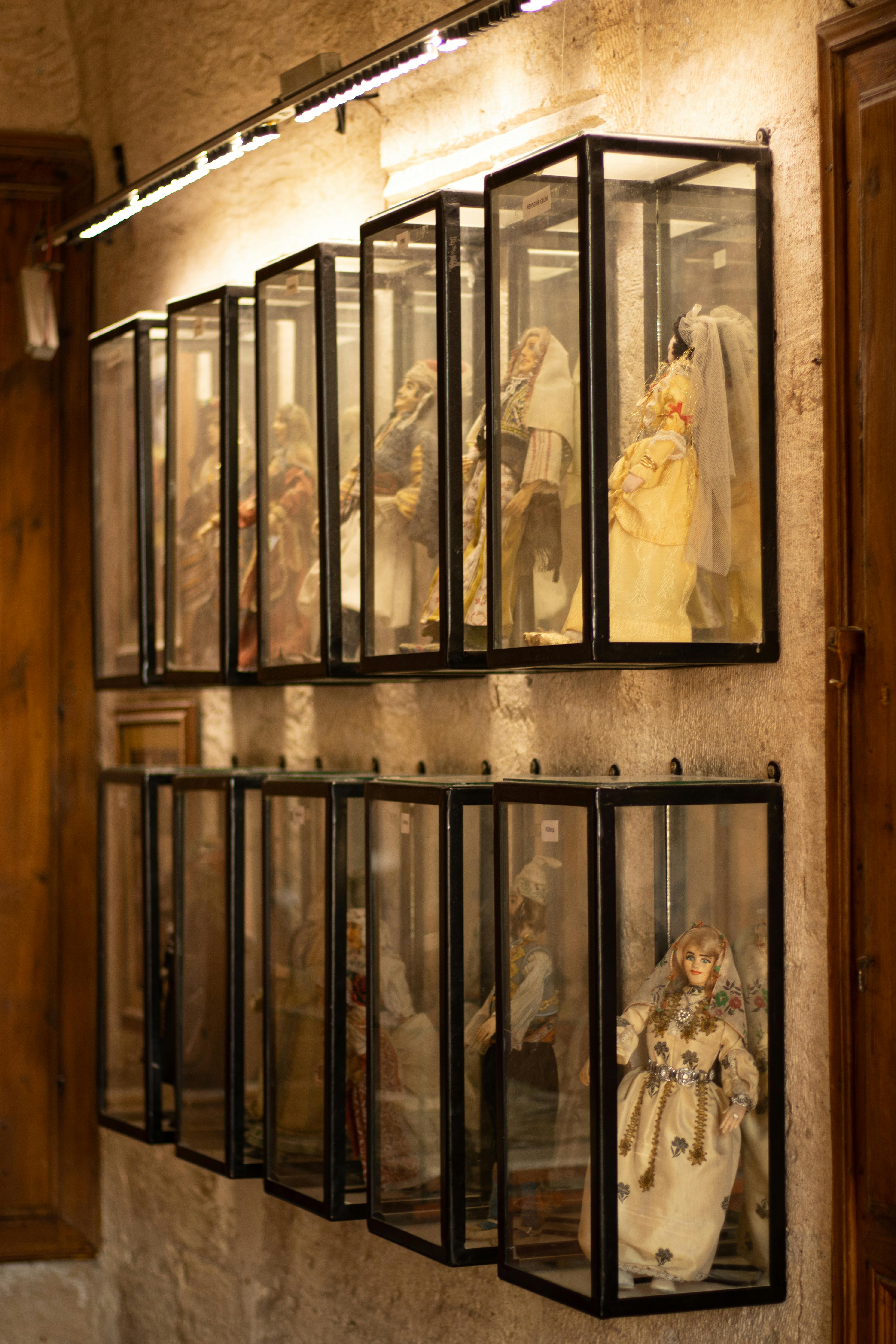 Vintage Dolls in Showcases on the Wall of the Museum · Free Stock Photo
