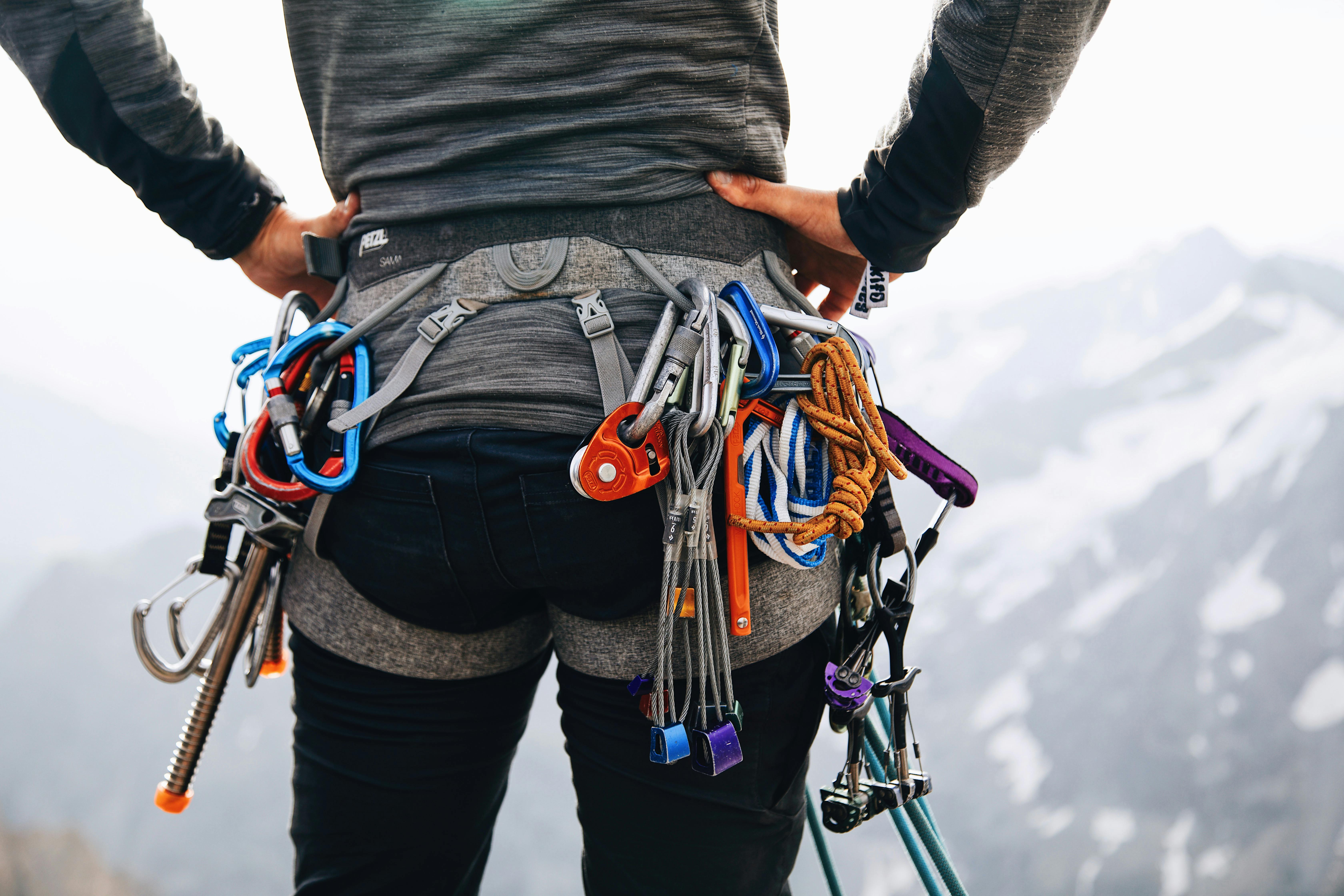 A person with a backpack and climbing gear on top of a mountain · Free ...