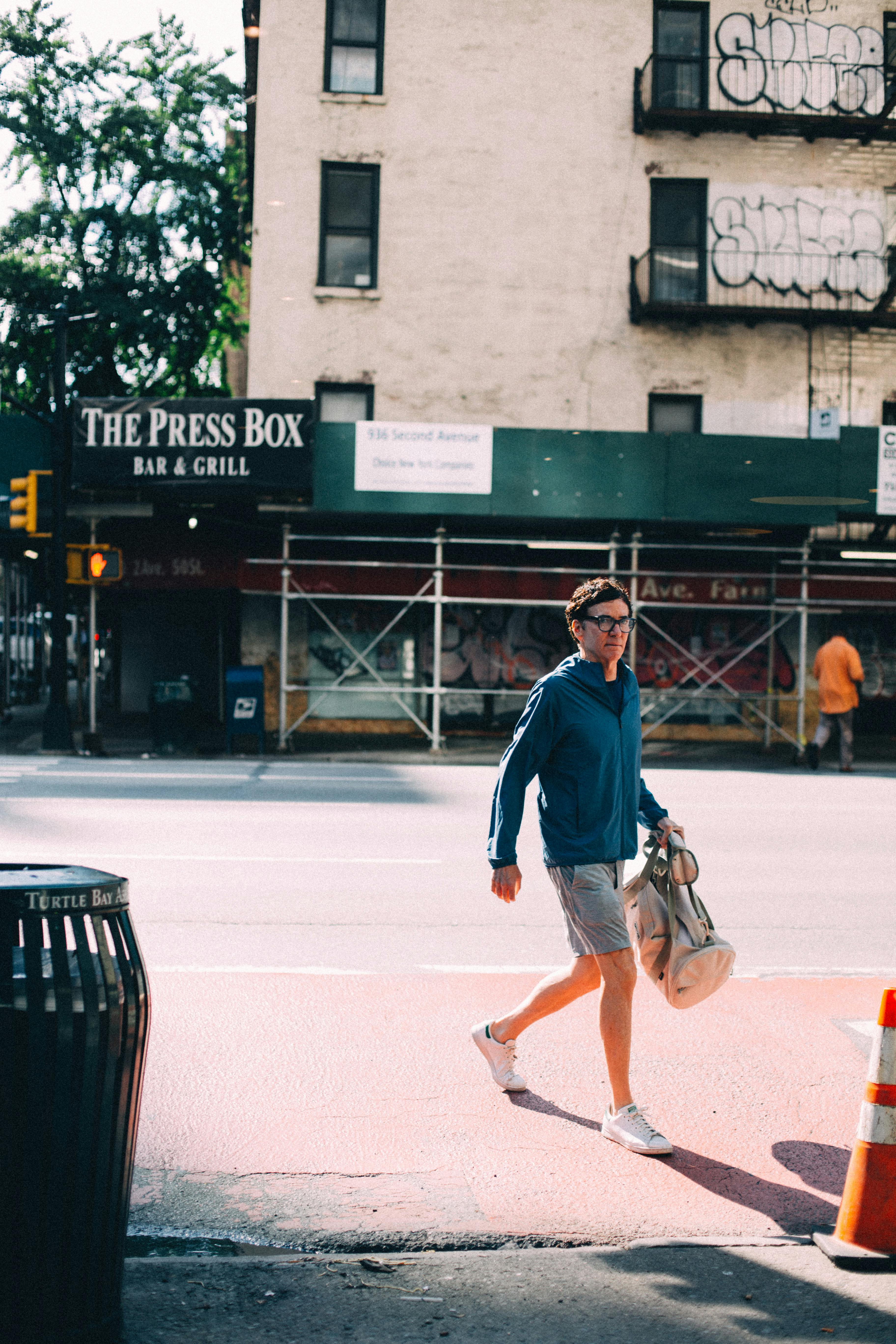 Man Walking with Bag on Sidewalk · Free Stock Photo