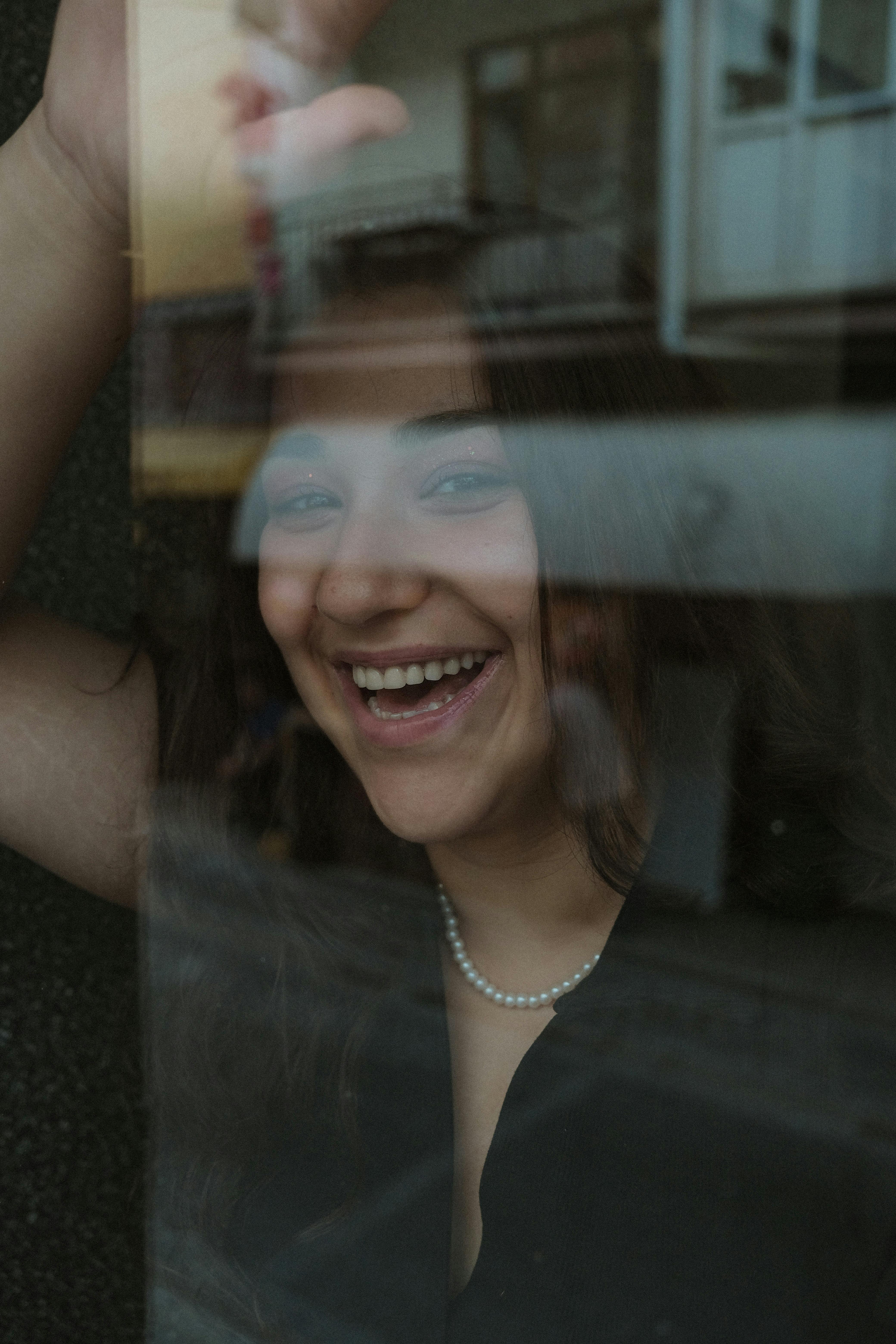 Photo of a Young Smiling Woman Standing behind the Window · Free Stock ...