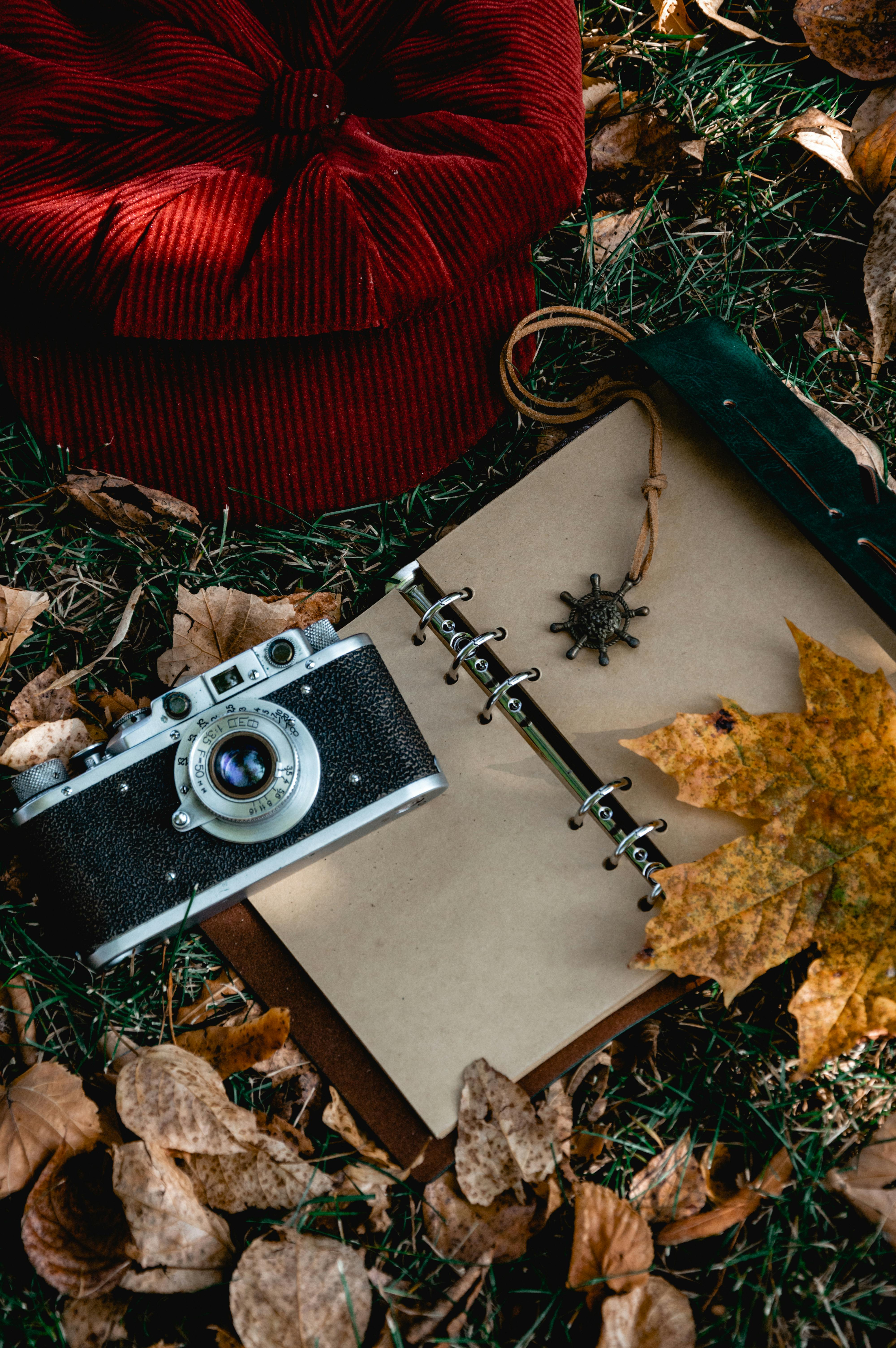 Analog Camera on Open Notebook · Free Stock Photo