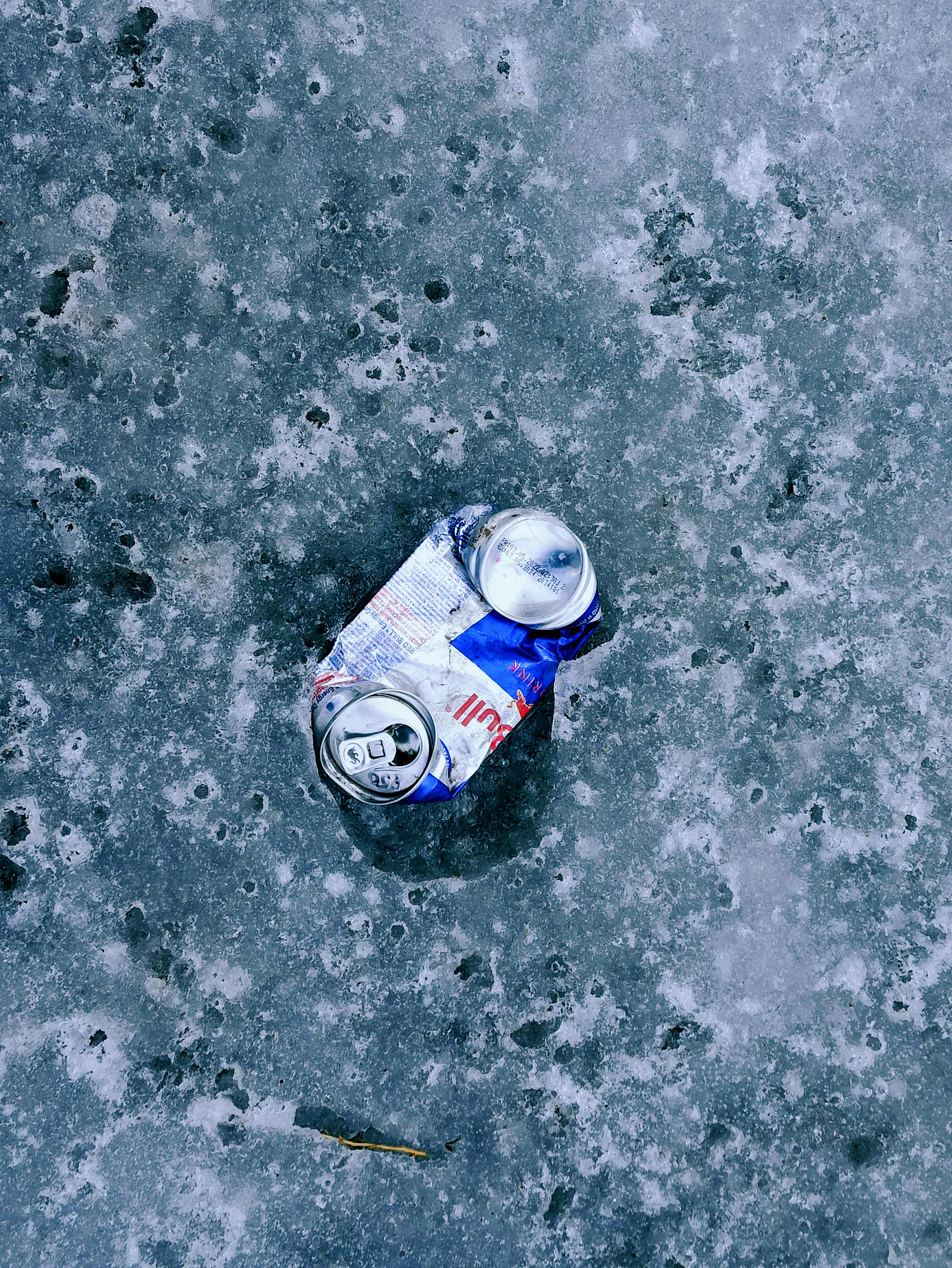 A Squashed Can on an Icy Ground · Free Stock Photo