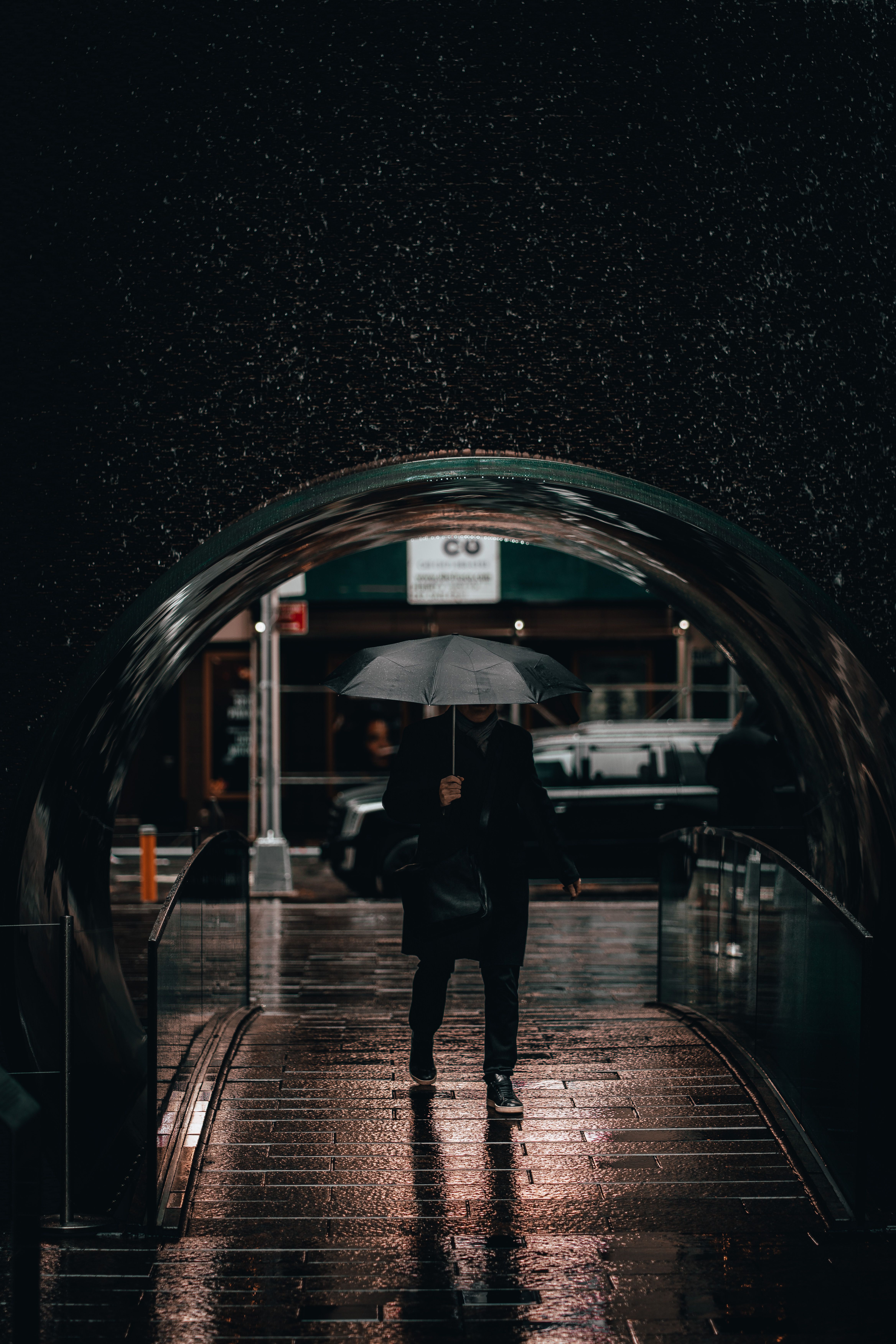 Man with Umbrella Walking on a Footbridge Under Arch · Free Stock Photo