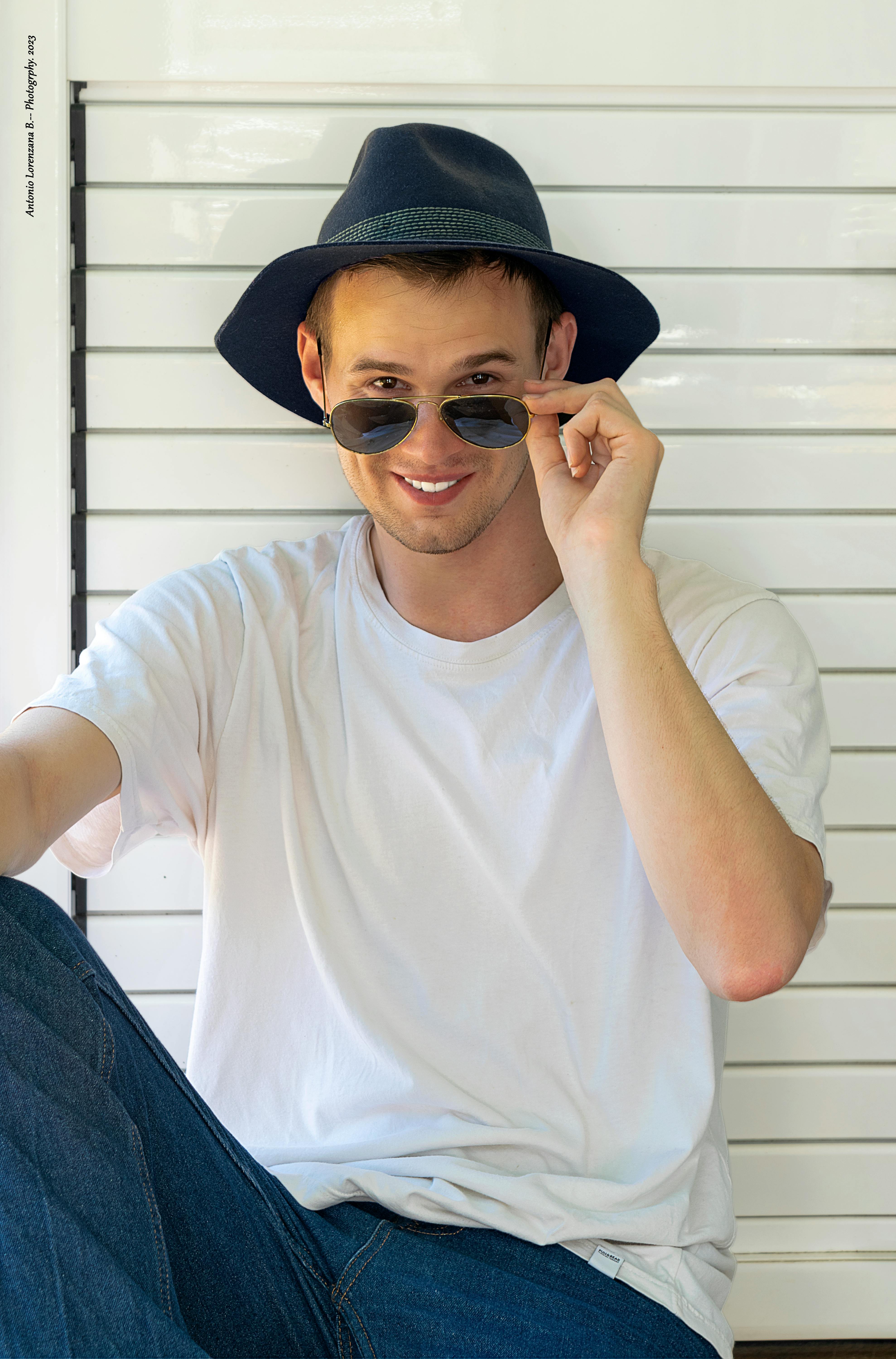 Smiling Man in Fedora Hat Holding Shades · Free Stock Photo