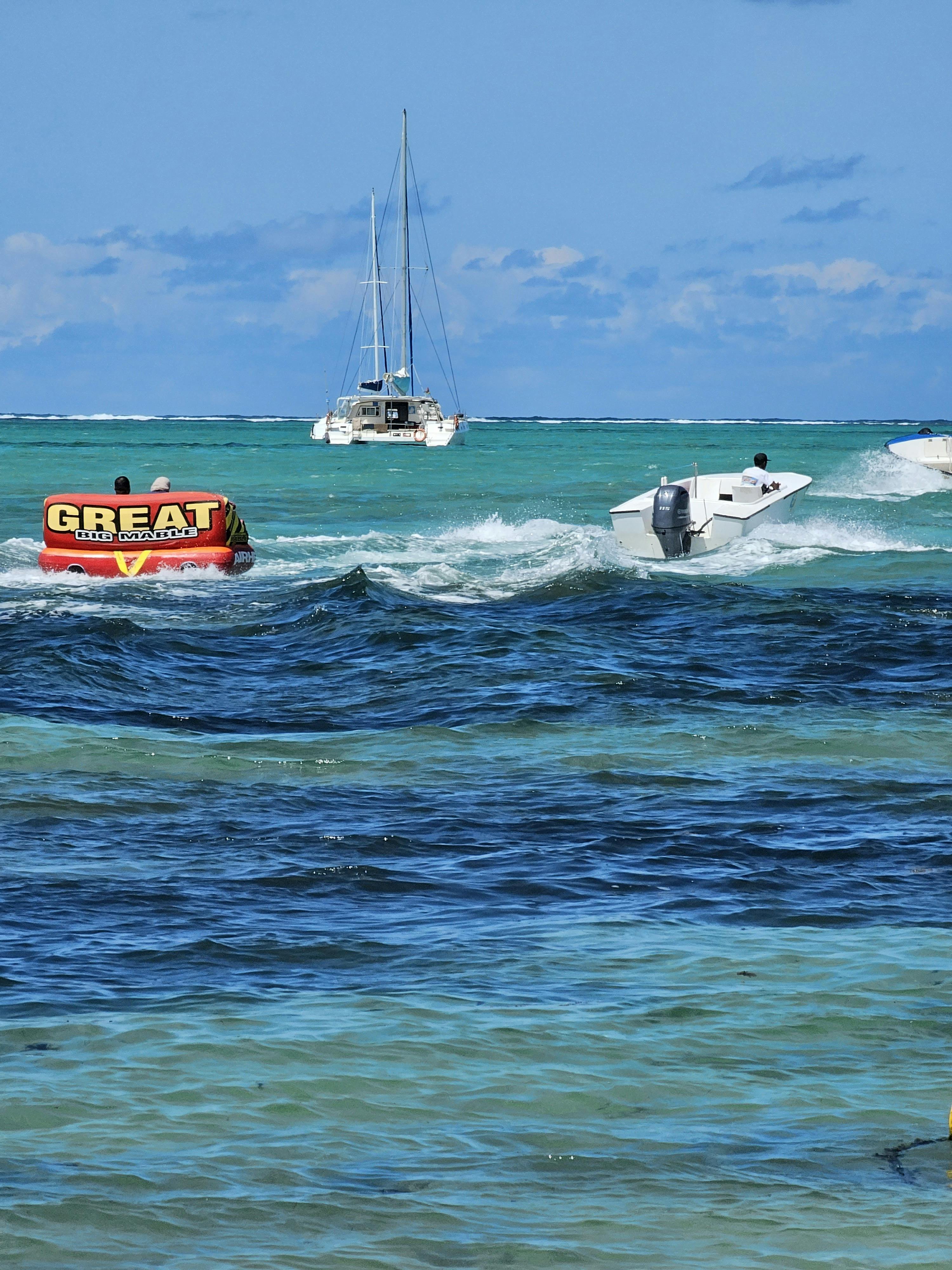 Motorboat Towing an Inflatable Tube · Free Stock Photo
