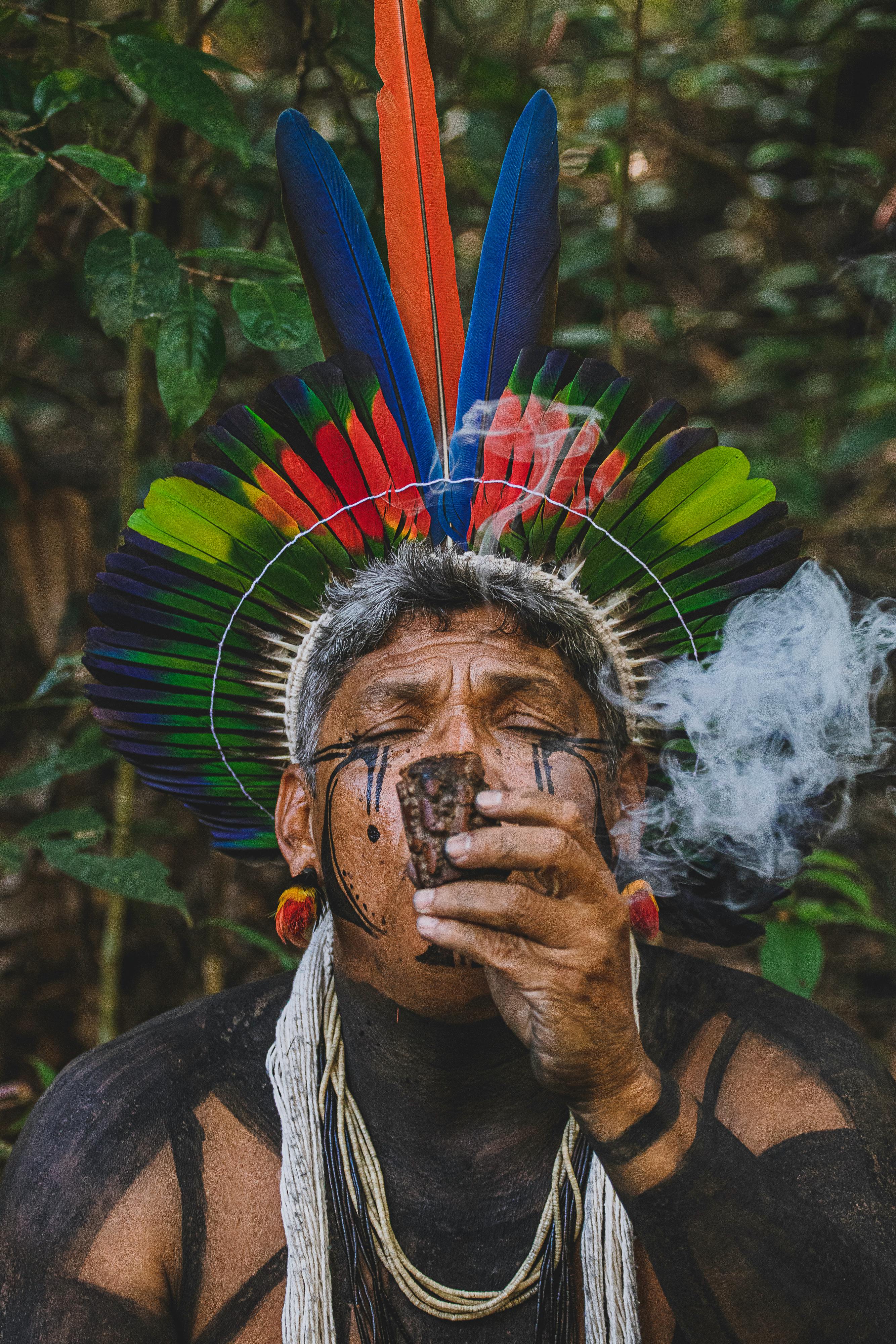 Man in Traditional Plume Smoking Pipe · Free Stock Photo