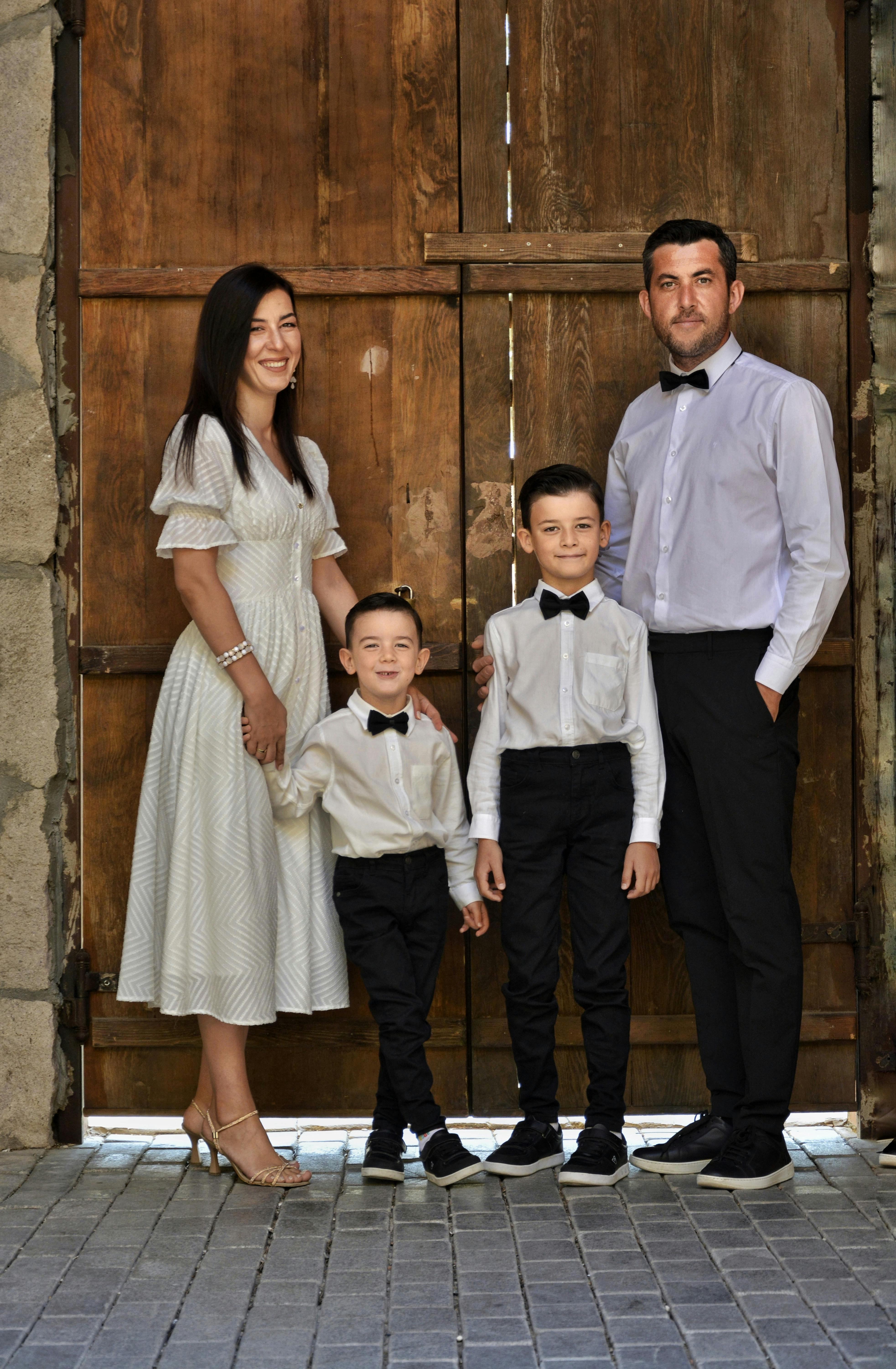 Elegantly Dressed Family with Two Boys Posing by Wooden Gate · Free ...