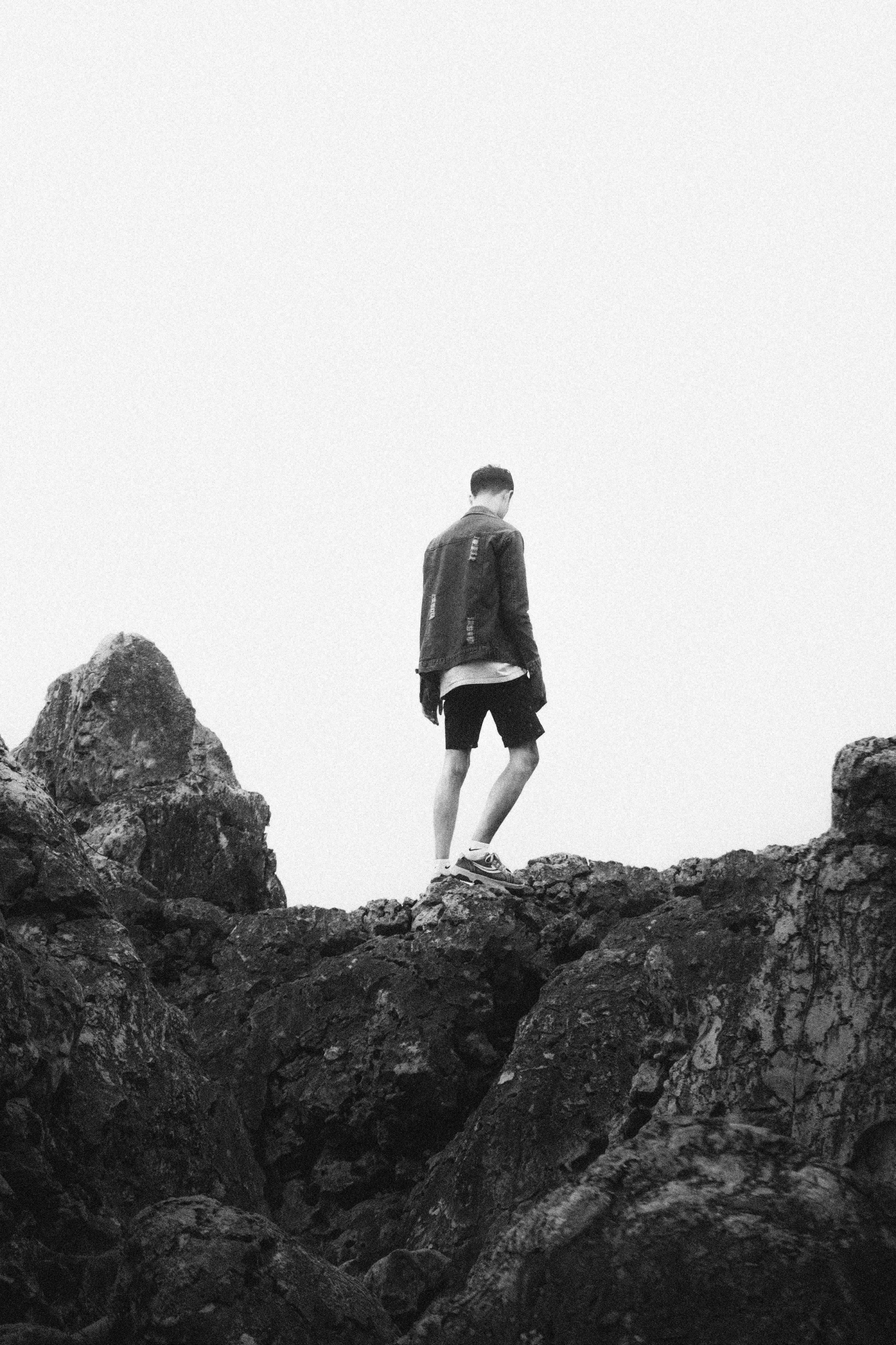 Man Standing on Rock Looking Down · Free Stock Photo