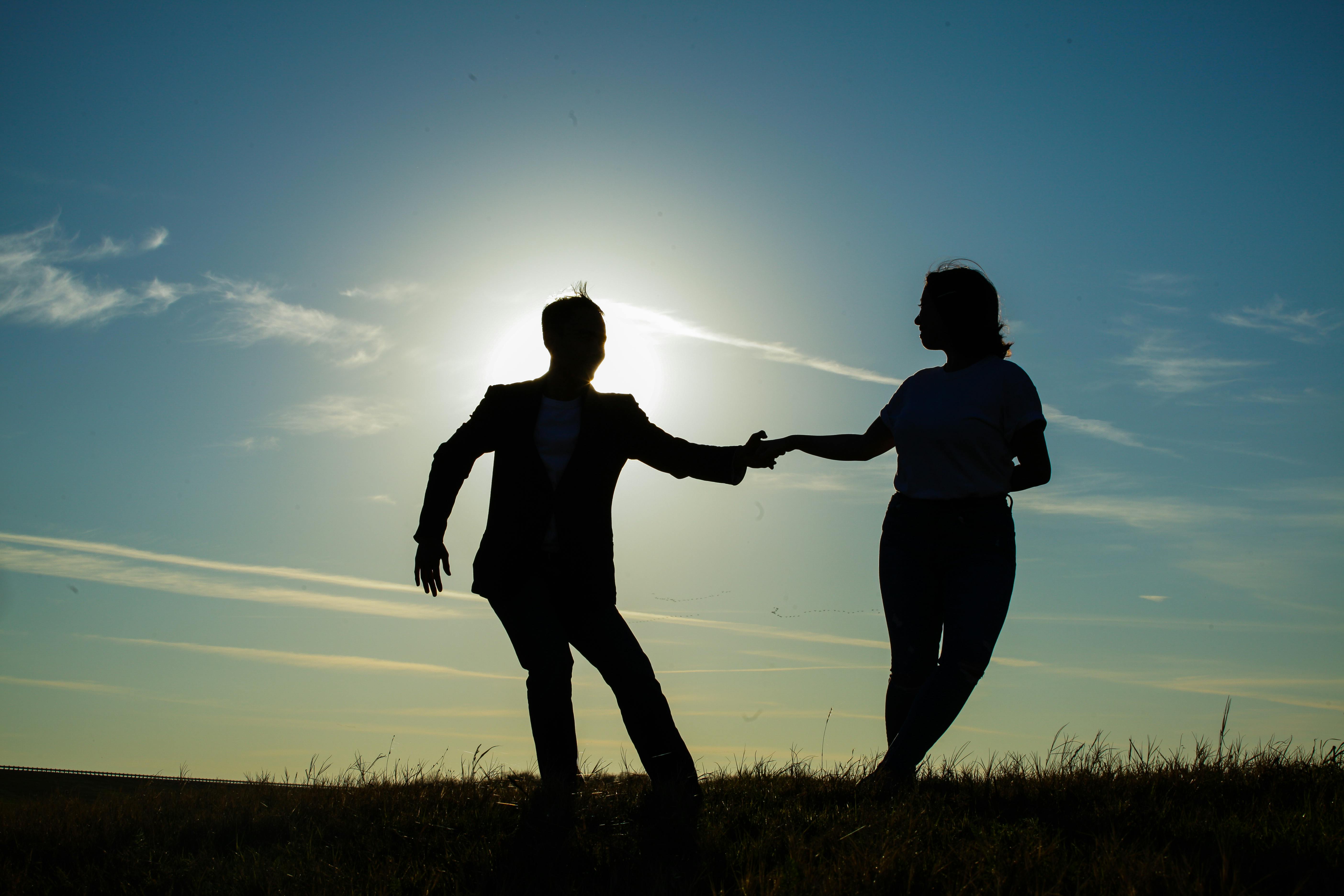 Two People Silhouette Holding Hands