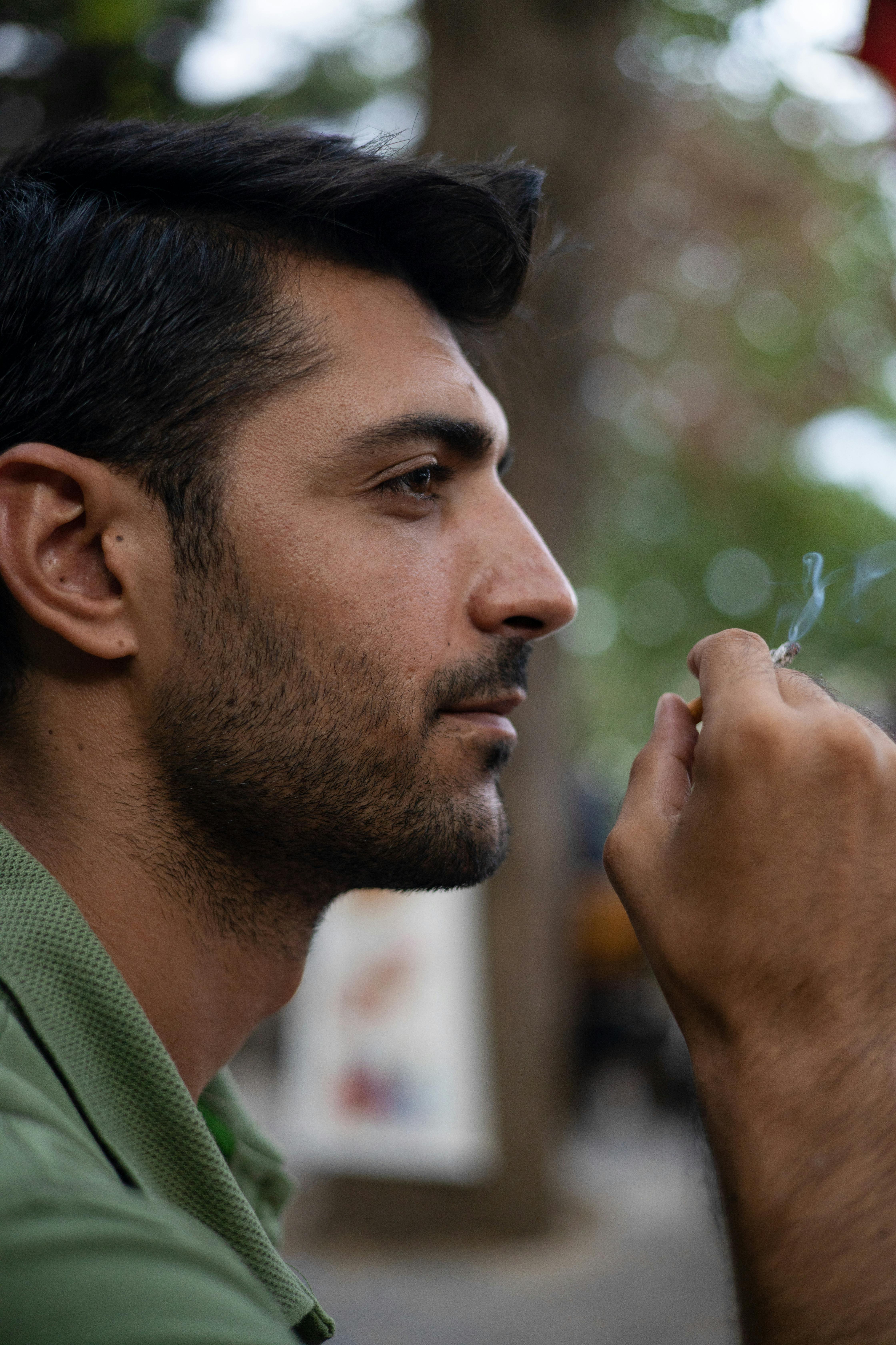 Side View of a Man Smoking a Cigarette · Free Stock Photo