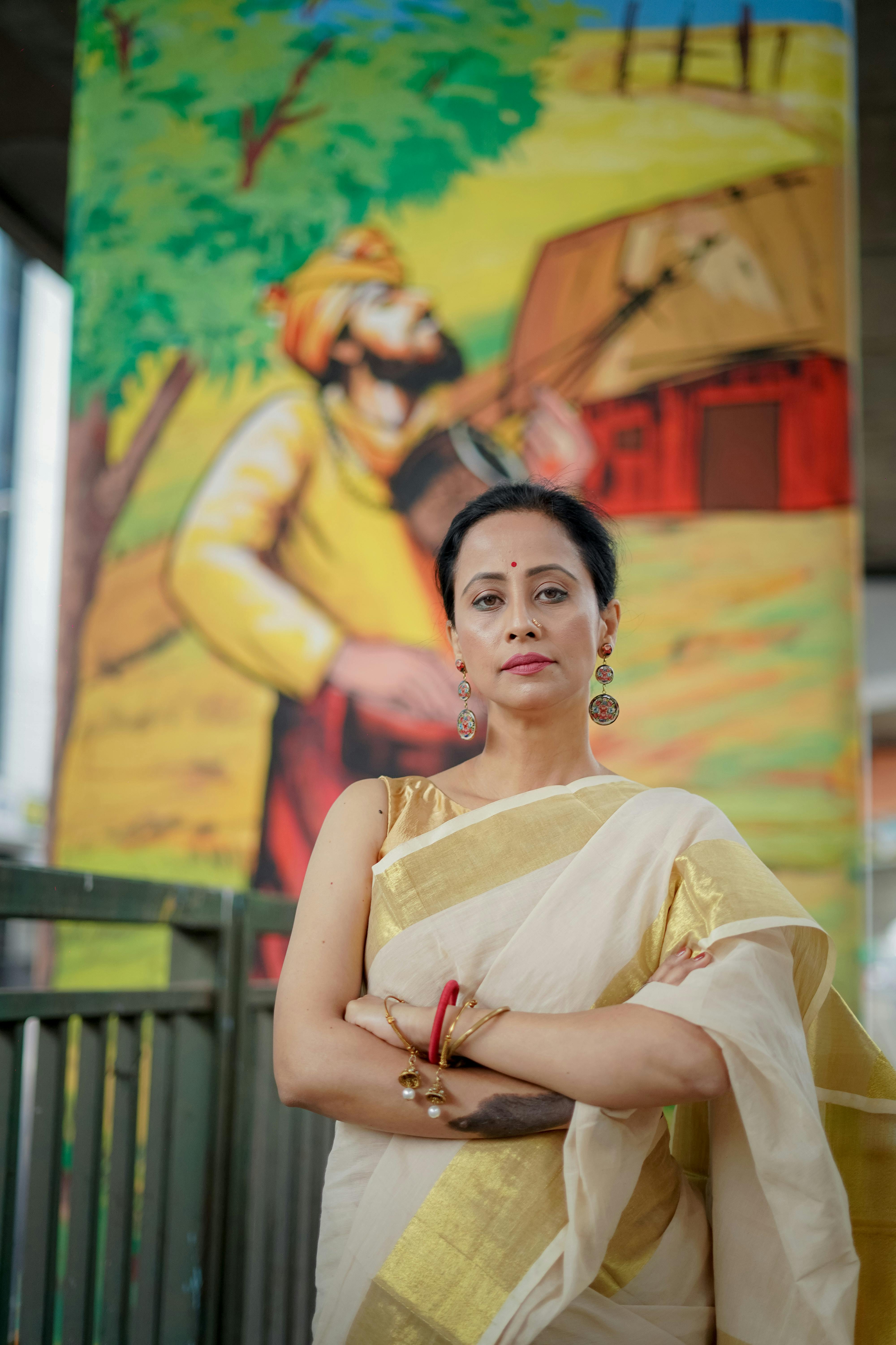 Woman in Traditional Clothing Standing with Mural behind · Free Stock Photo